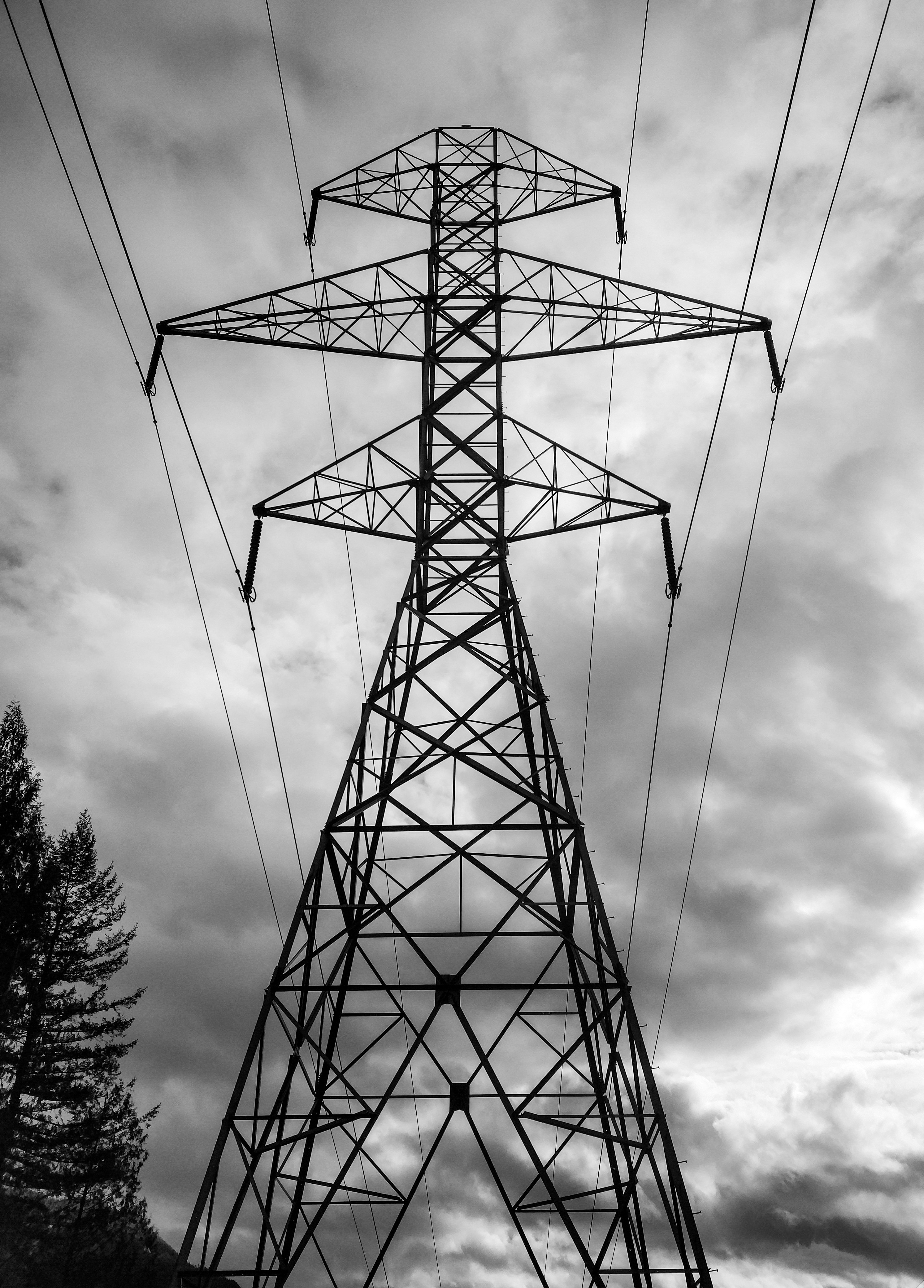 A power pylon stands against a cloudy sky.