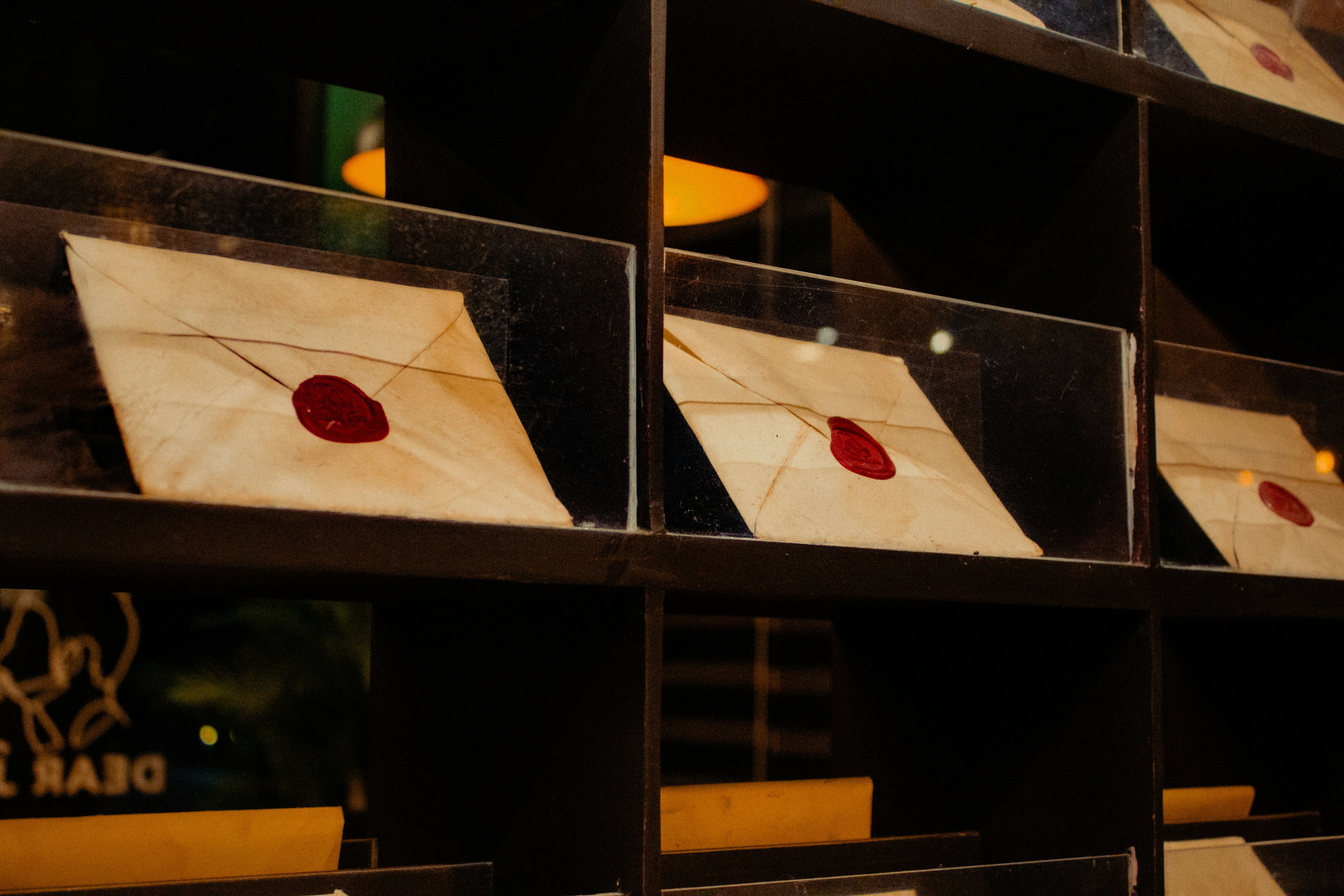 Vintage envelopes with wax seals displayed in a wooden shelf, evoking a sense of nostalgia and mystery.