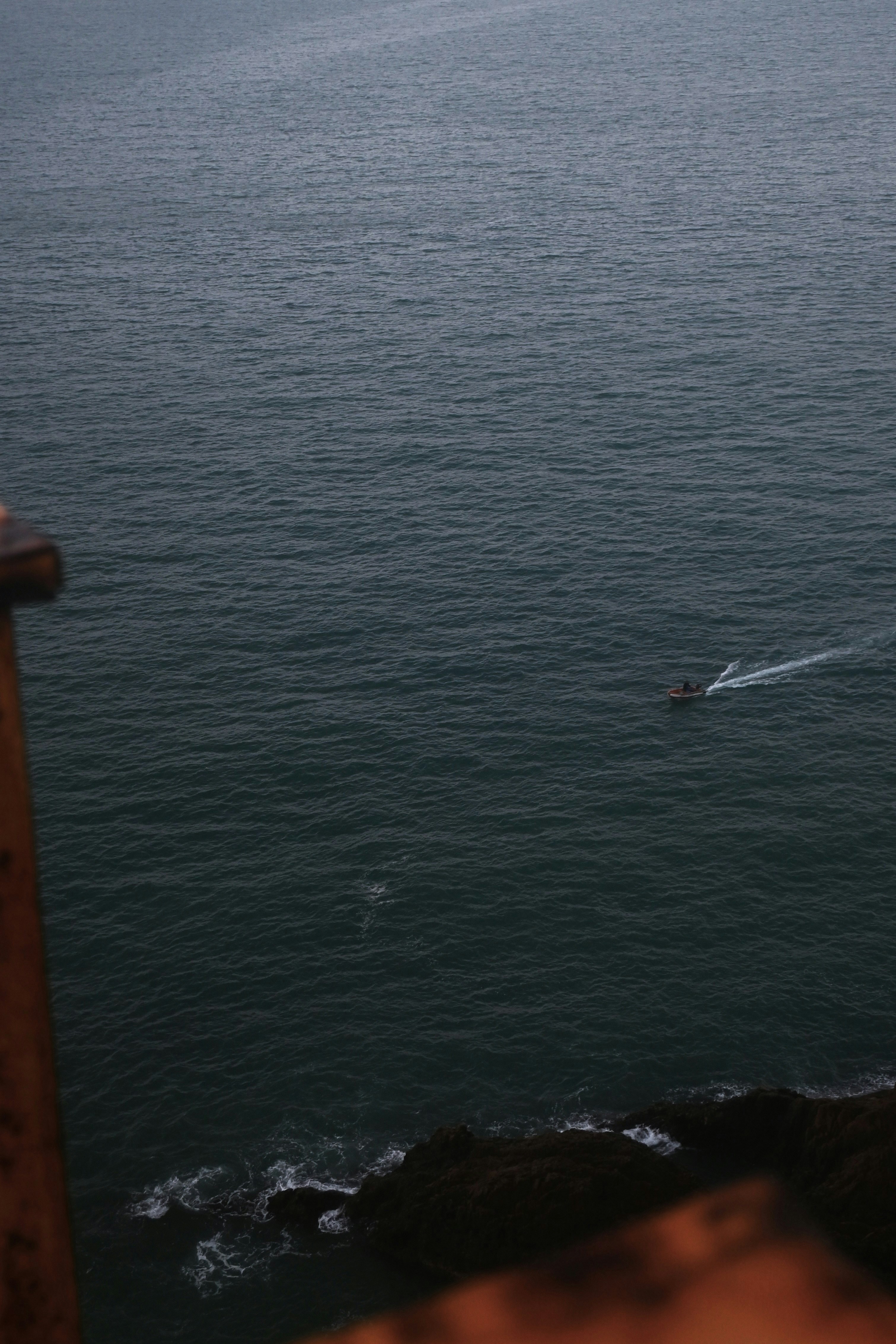 A boat travels across a vast, dark ocean.