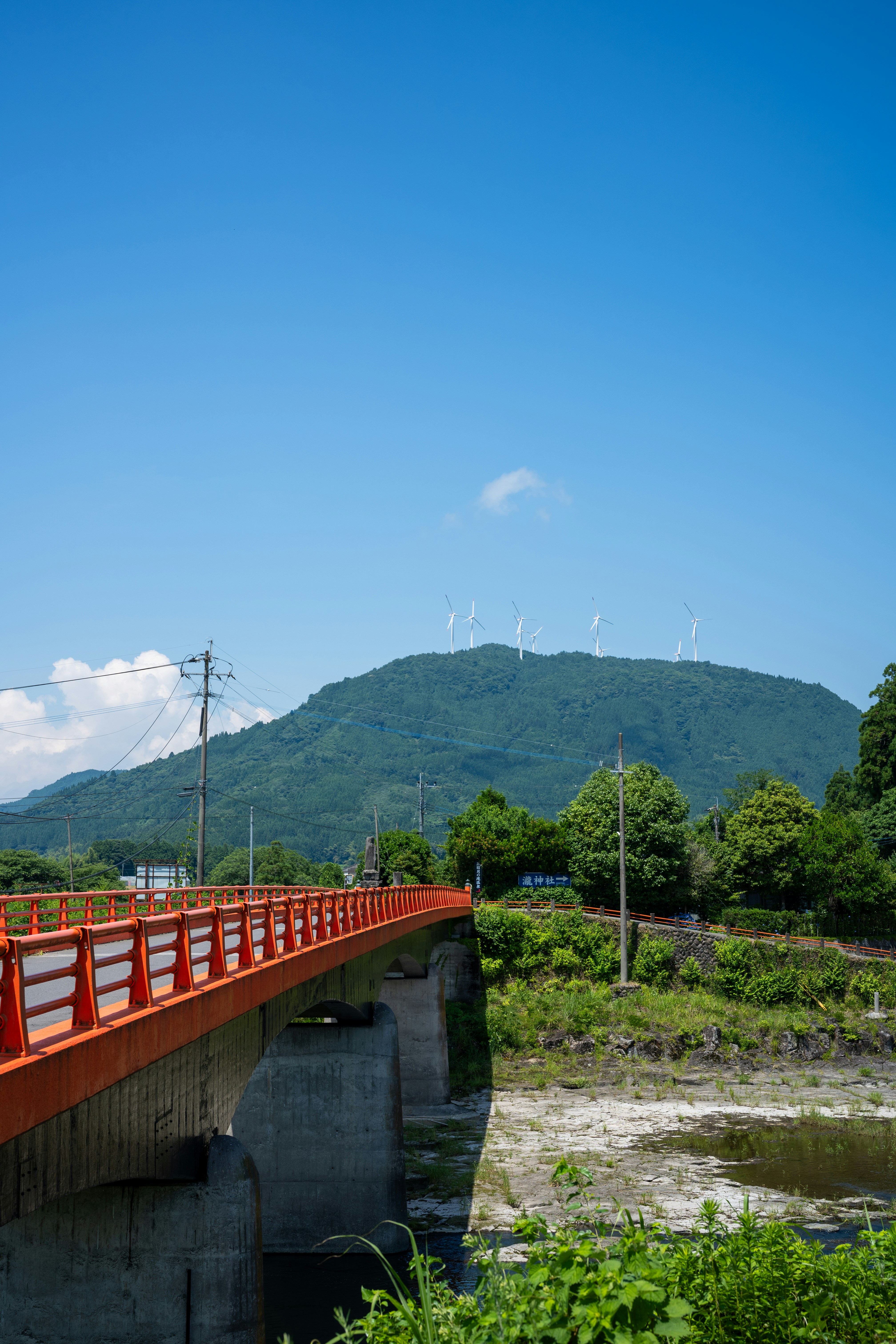A red bridge spans over a scenic landscape.