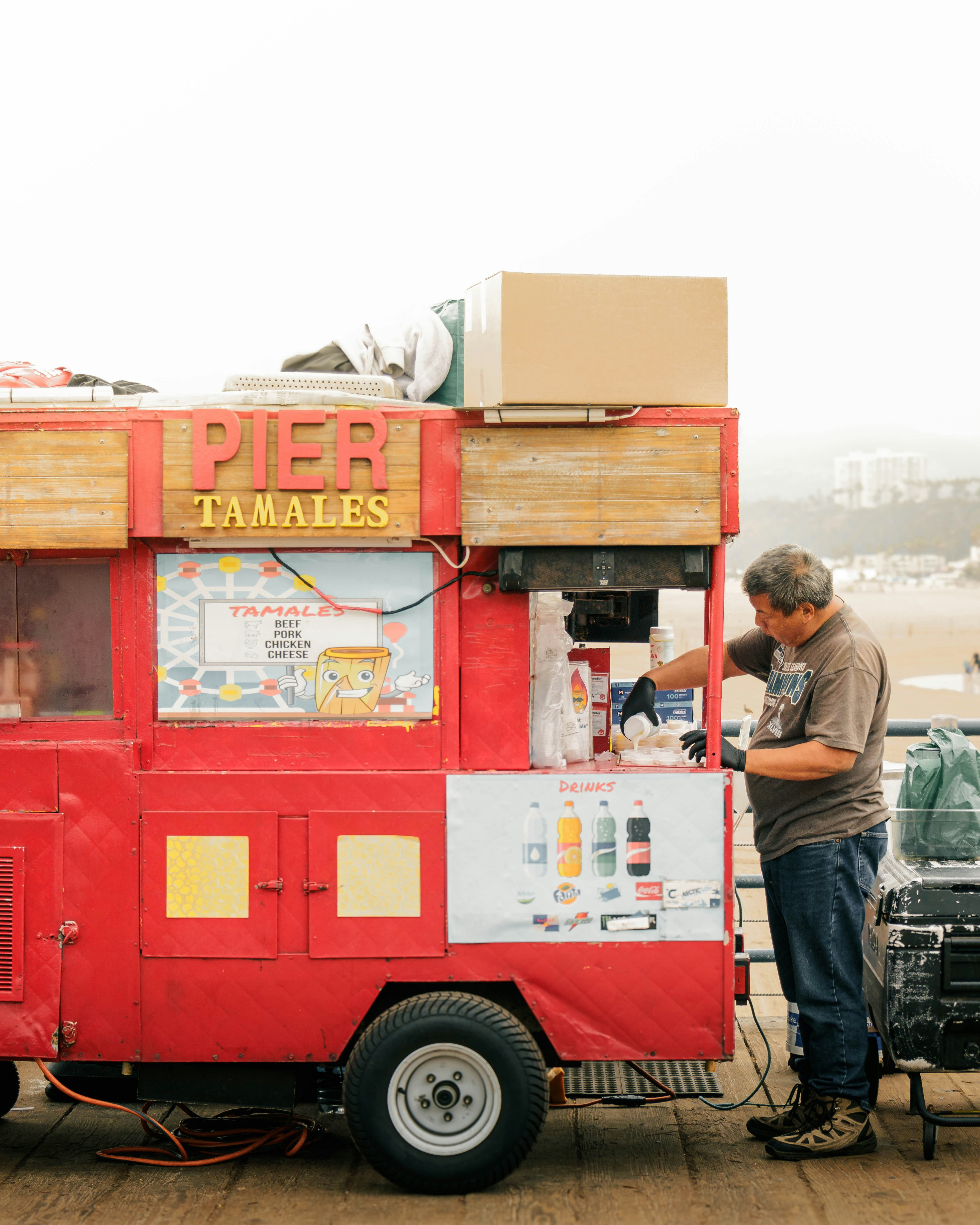 A man is serving food from a pier tamales stand. photo – Free Street ...