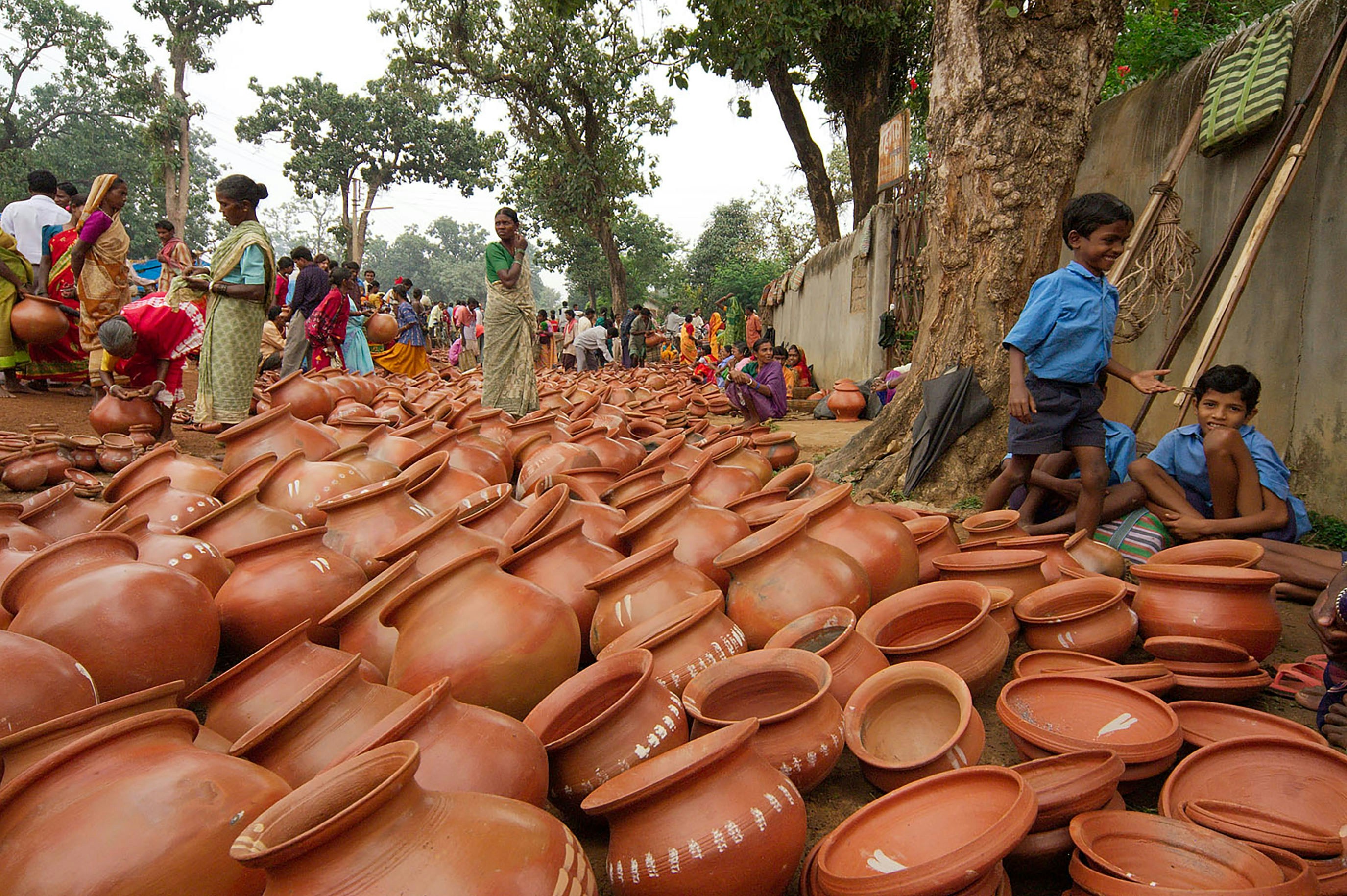 Vibrant marketplace bustling with people and rows of handcrafted clay pots, showcasing the artistry and cultural significance of pottery. Children play amidst the wares.