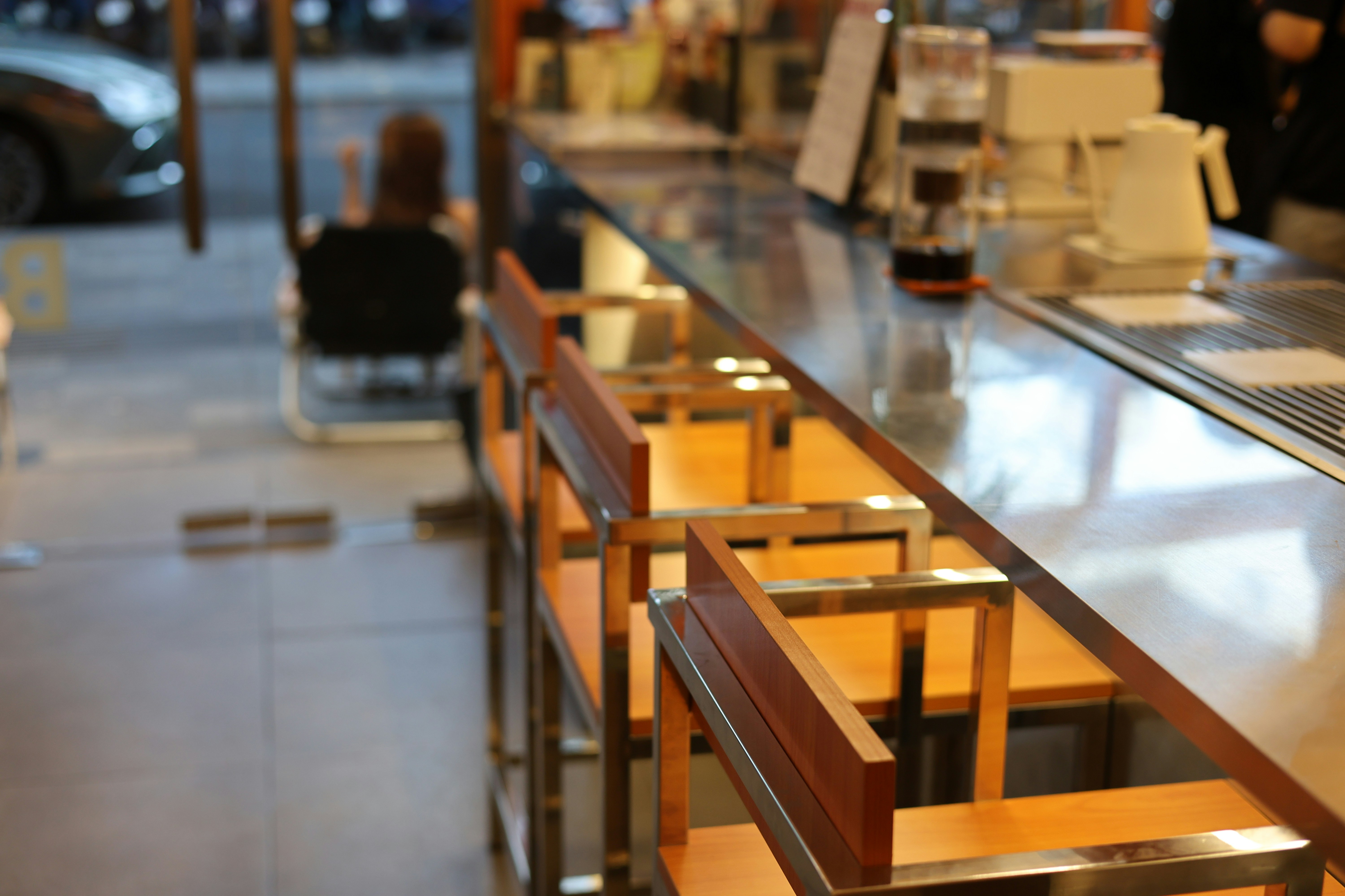 Warm Geometry at a Café Bar: Wood and Metal in Soft Blur