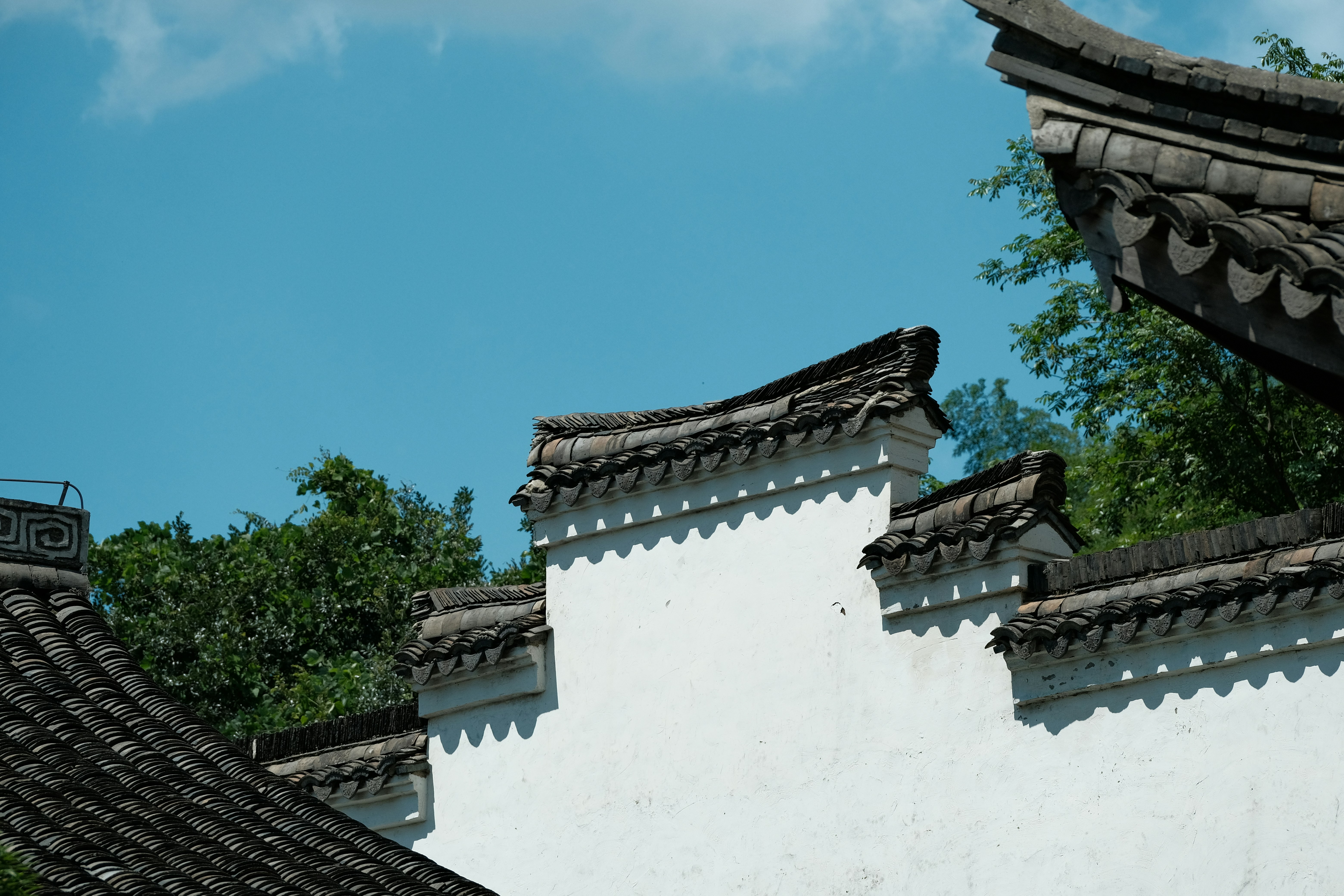 Traditional architecture's rooftops and a white wall.