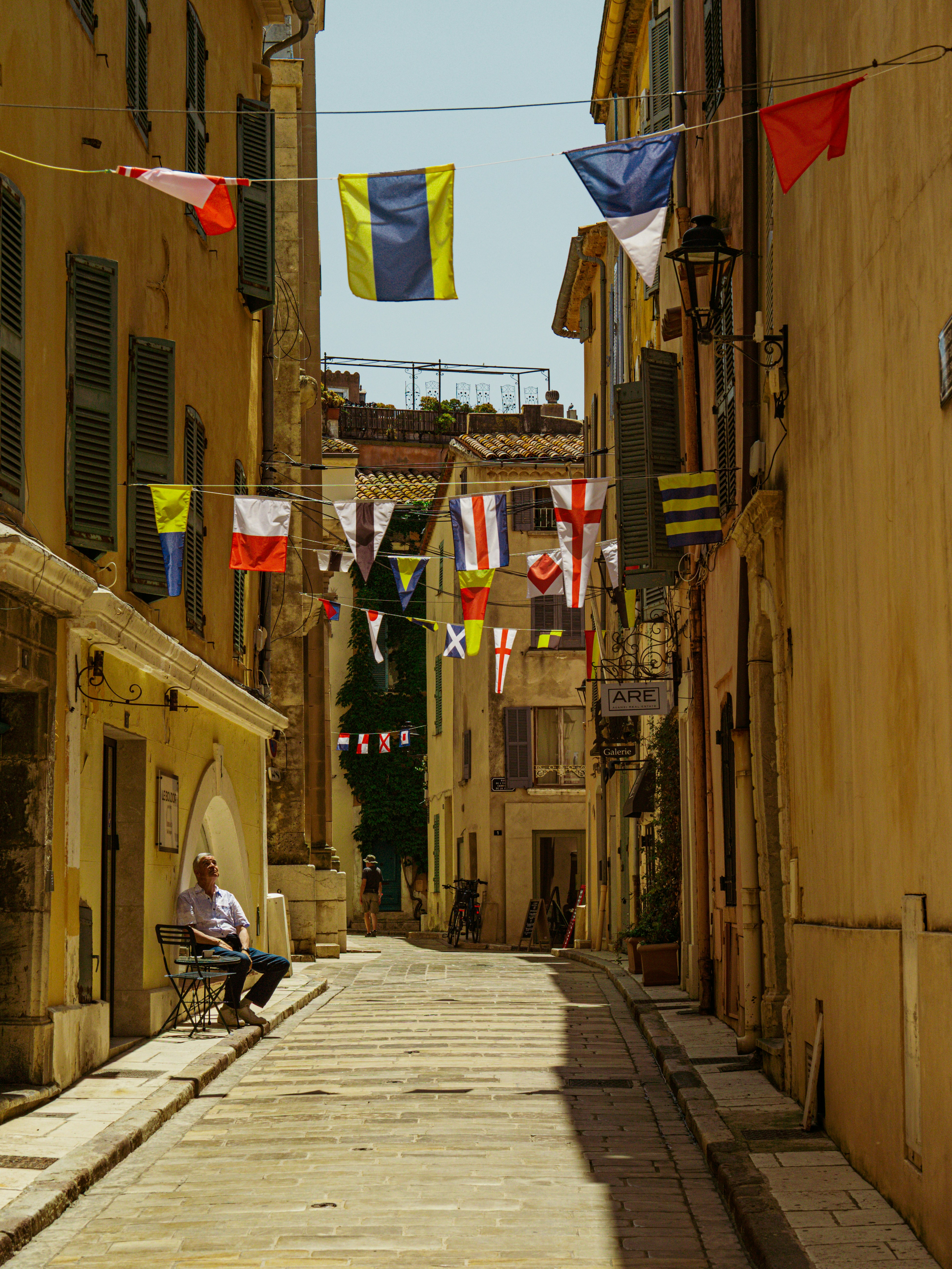 A narrow street is lined with colorful flags.