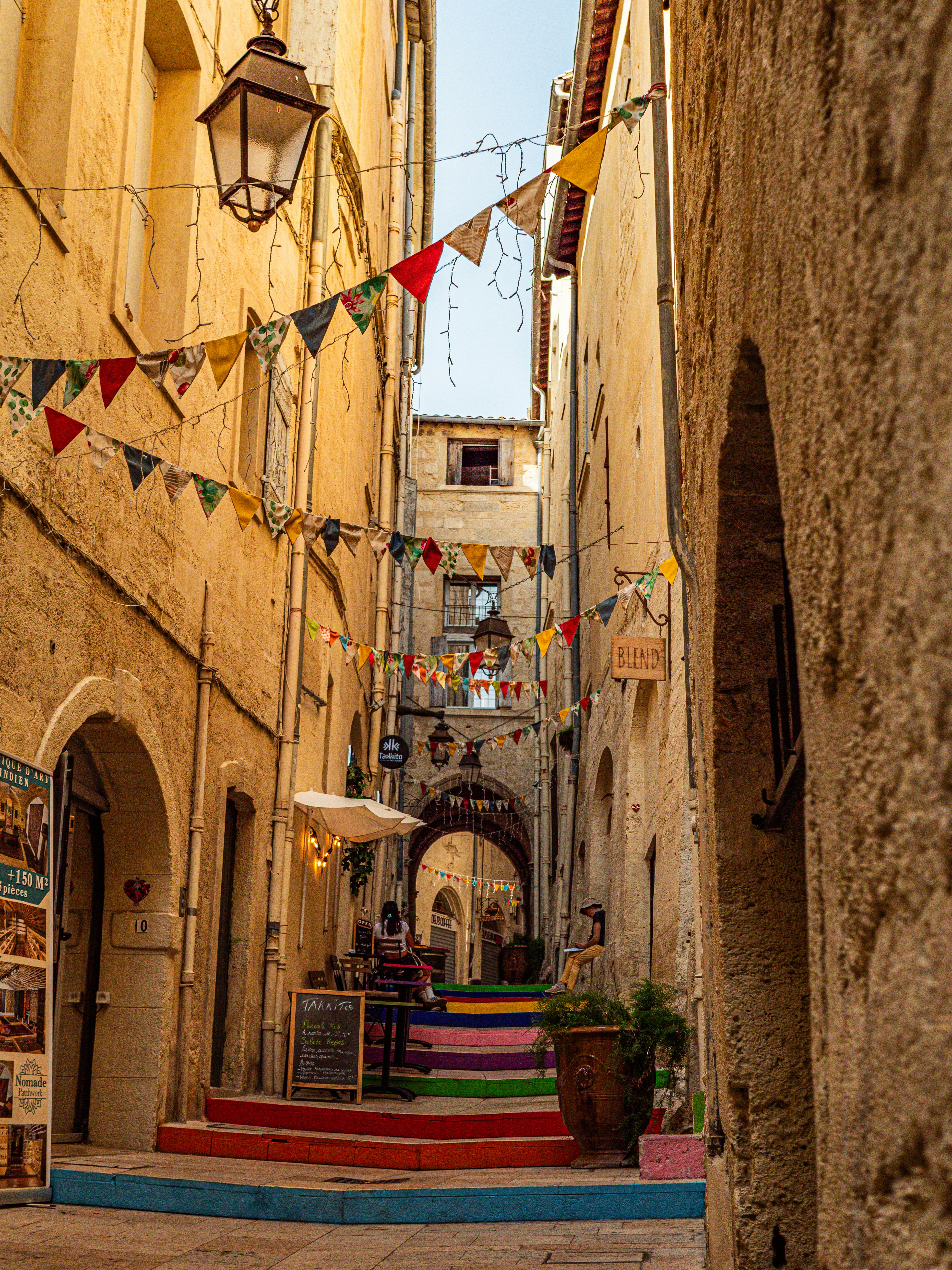 Colorful Calle: A Sunlit Archway Alley of Festive Flags
