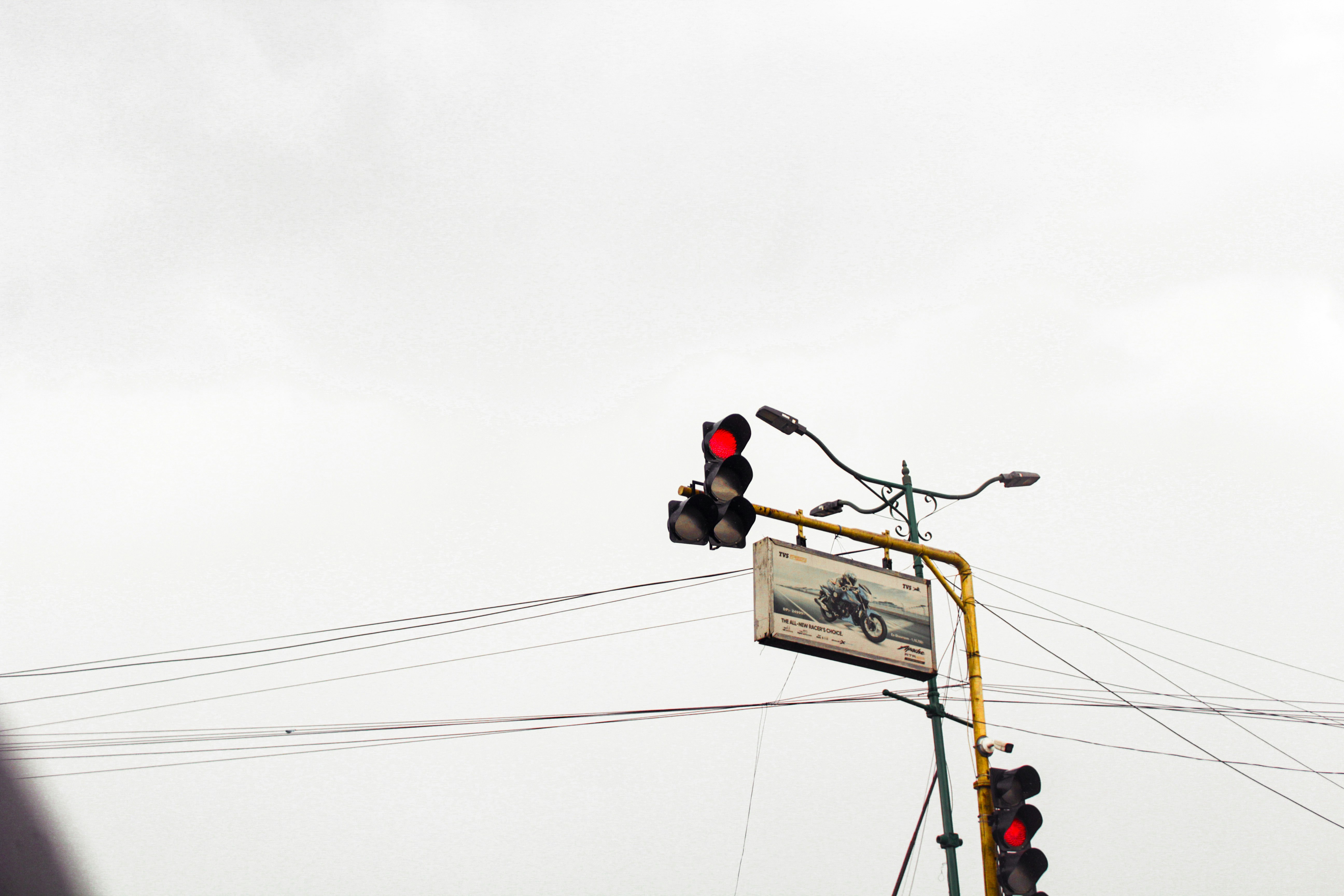 Red traffic lights against a cloudy sky.