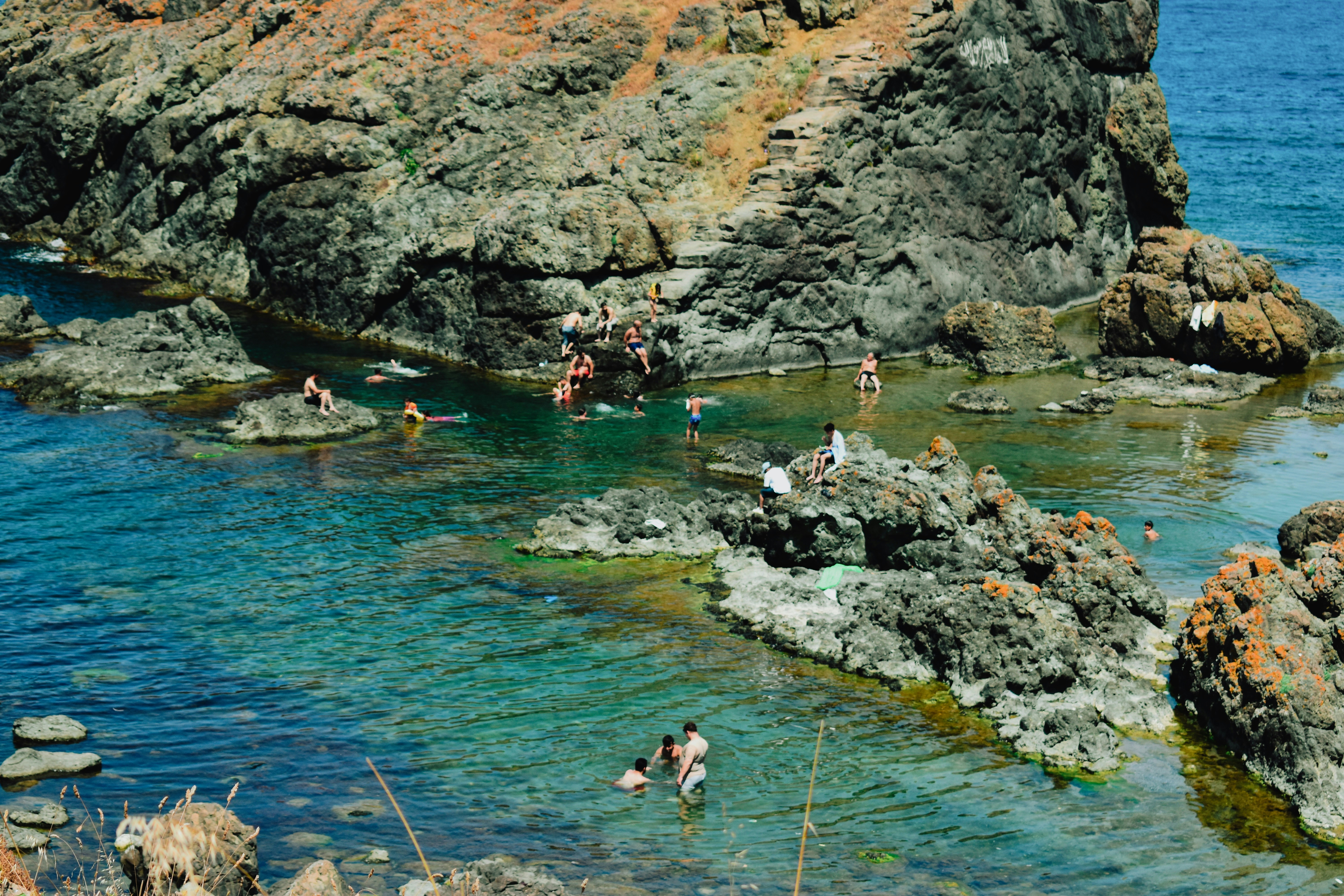 People swim in a scenic cove. photo – Free Image on Unsplash