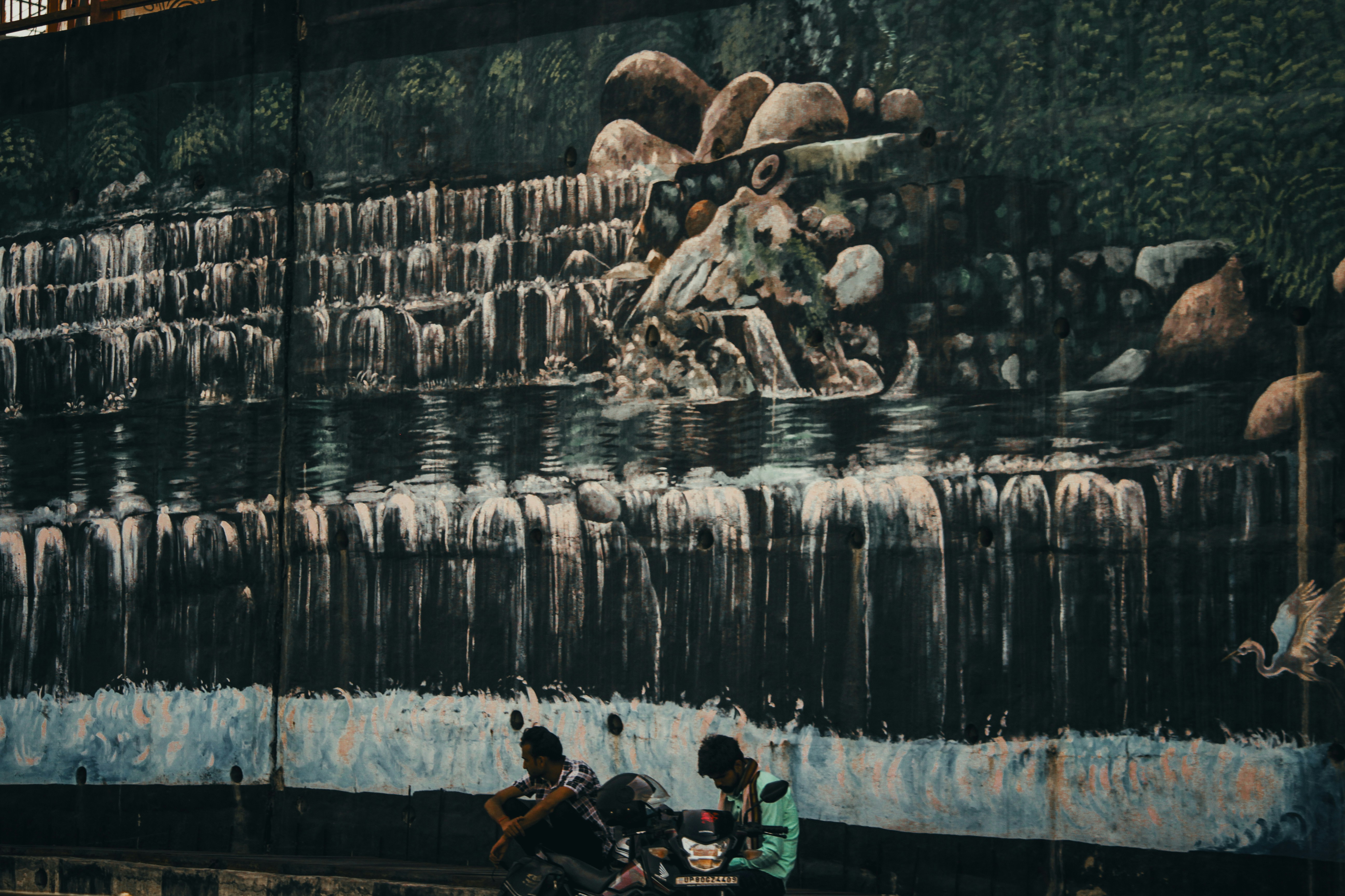 Concrete Cascade: Riders Pause by a Street-Wide Waterfall Mural