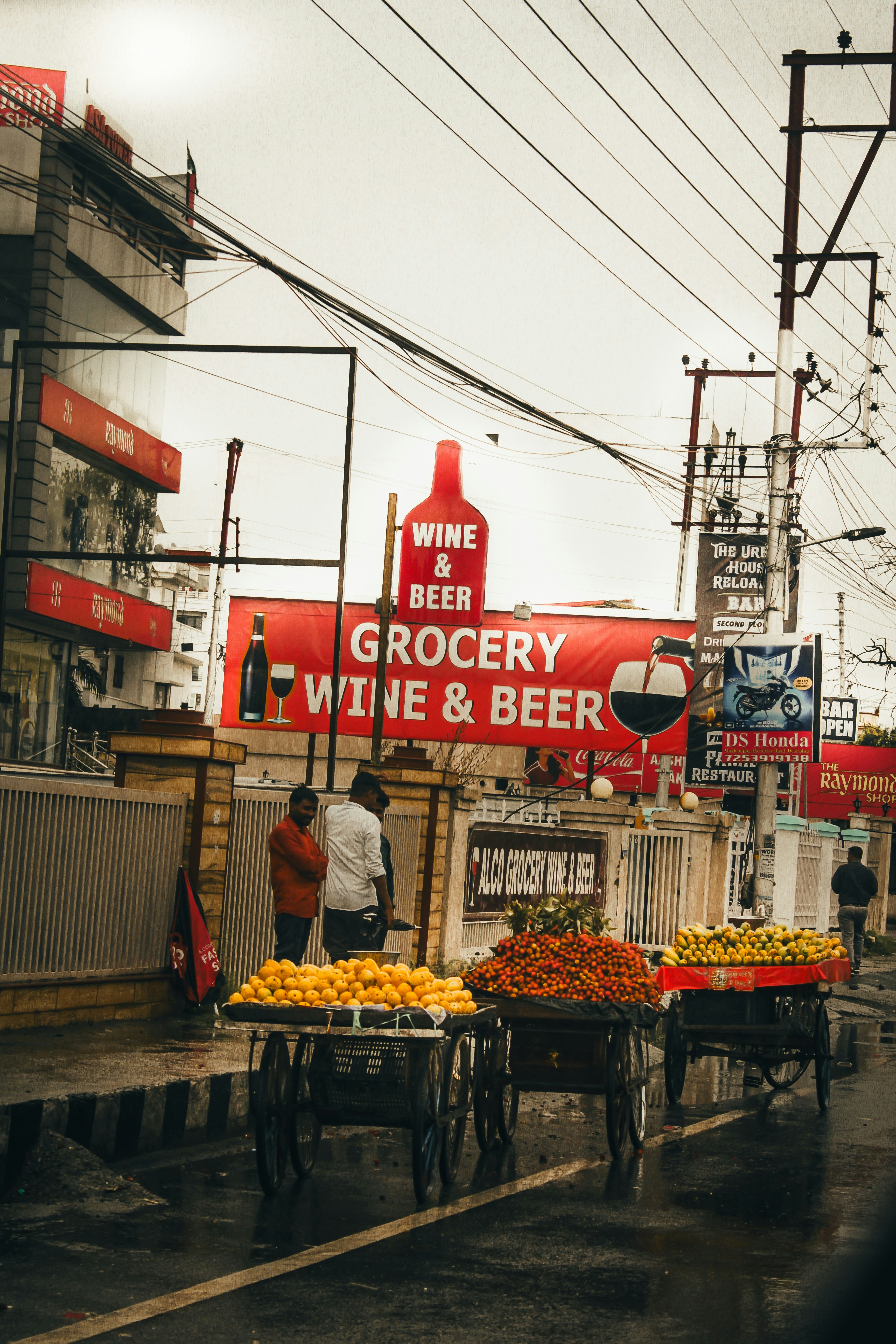 Street Market Frame: Fruits on Wheels Beneath a Bold Grocery Sign