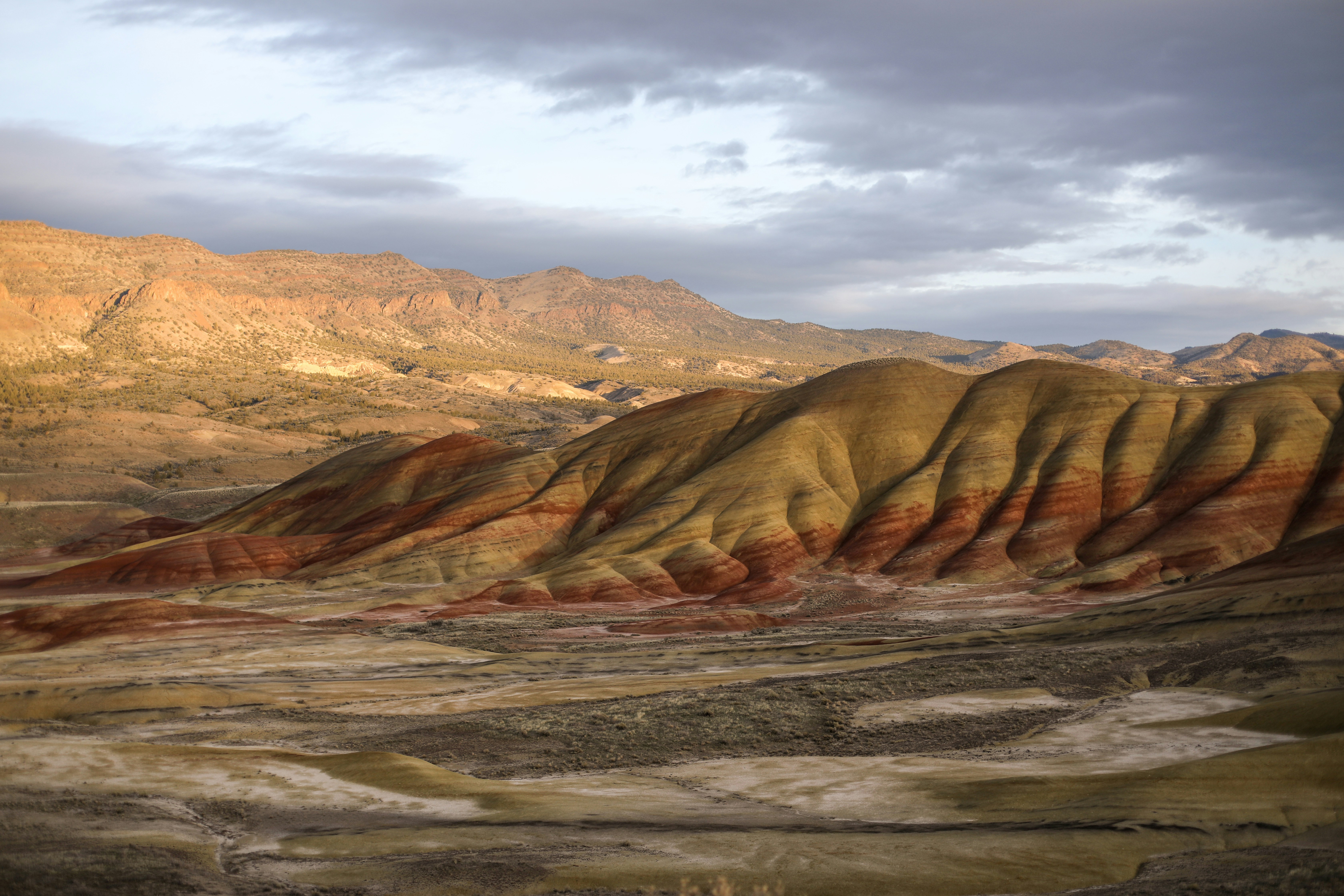 Colorful painted hills landscape under a cloudy sky.