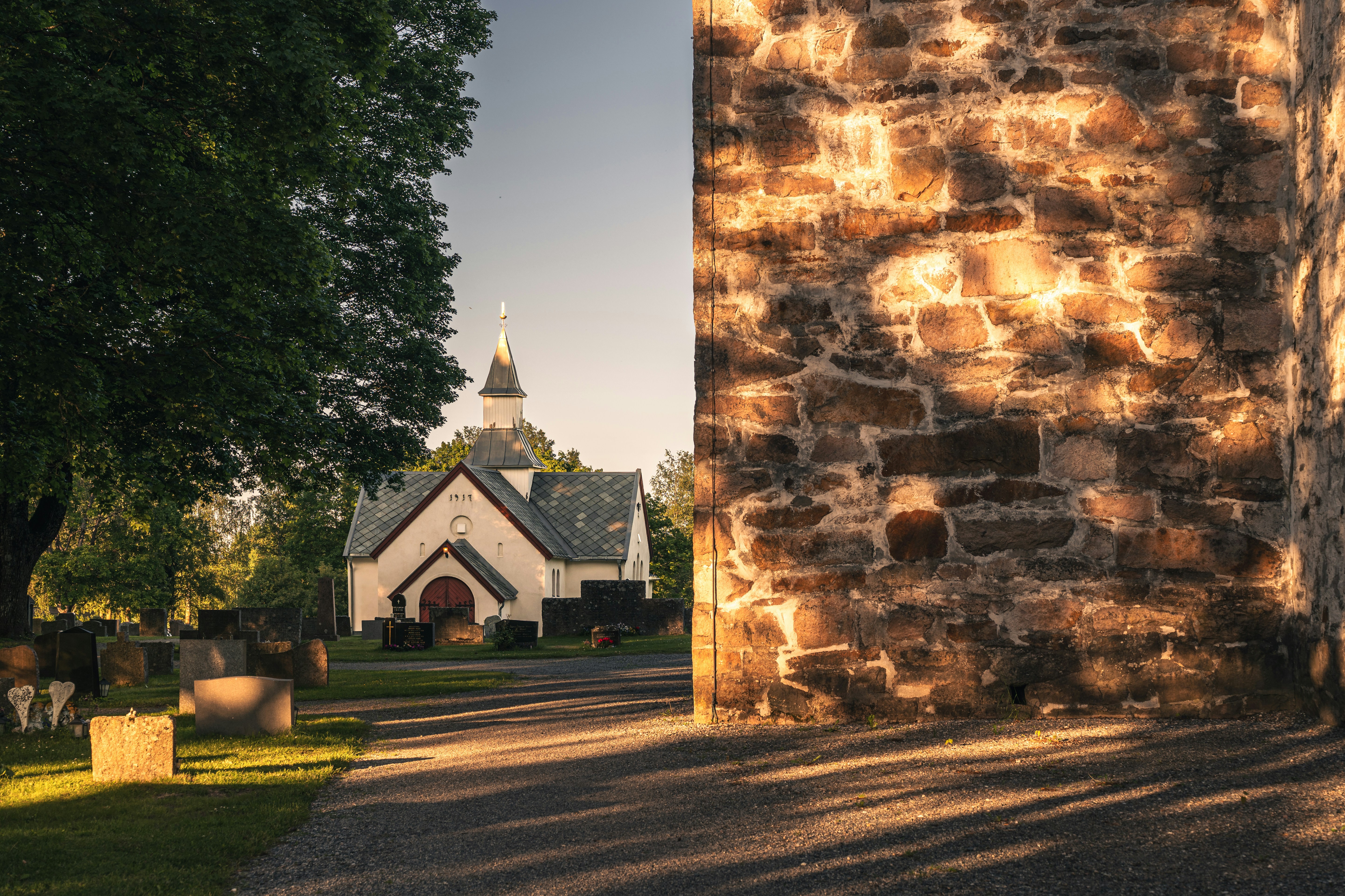 Light Between Stones: A Chapel Framed by an Ancient Wall at Golden Hour