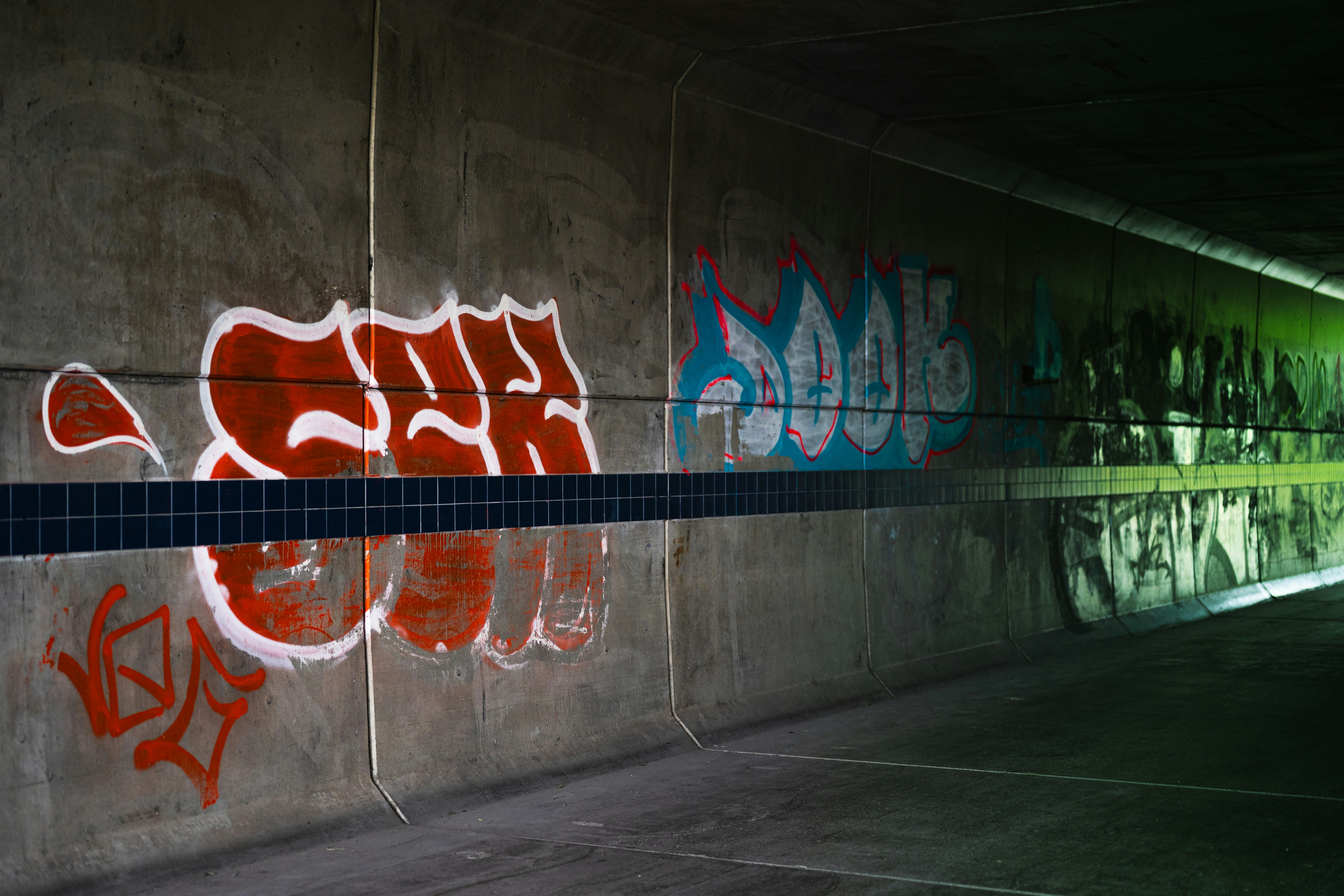 Urban tunnel graffiti art. | Graffiti art decorates an underground tunnel wall.