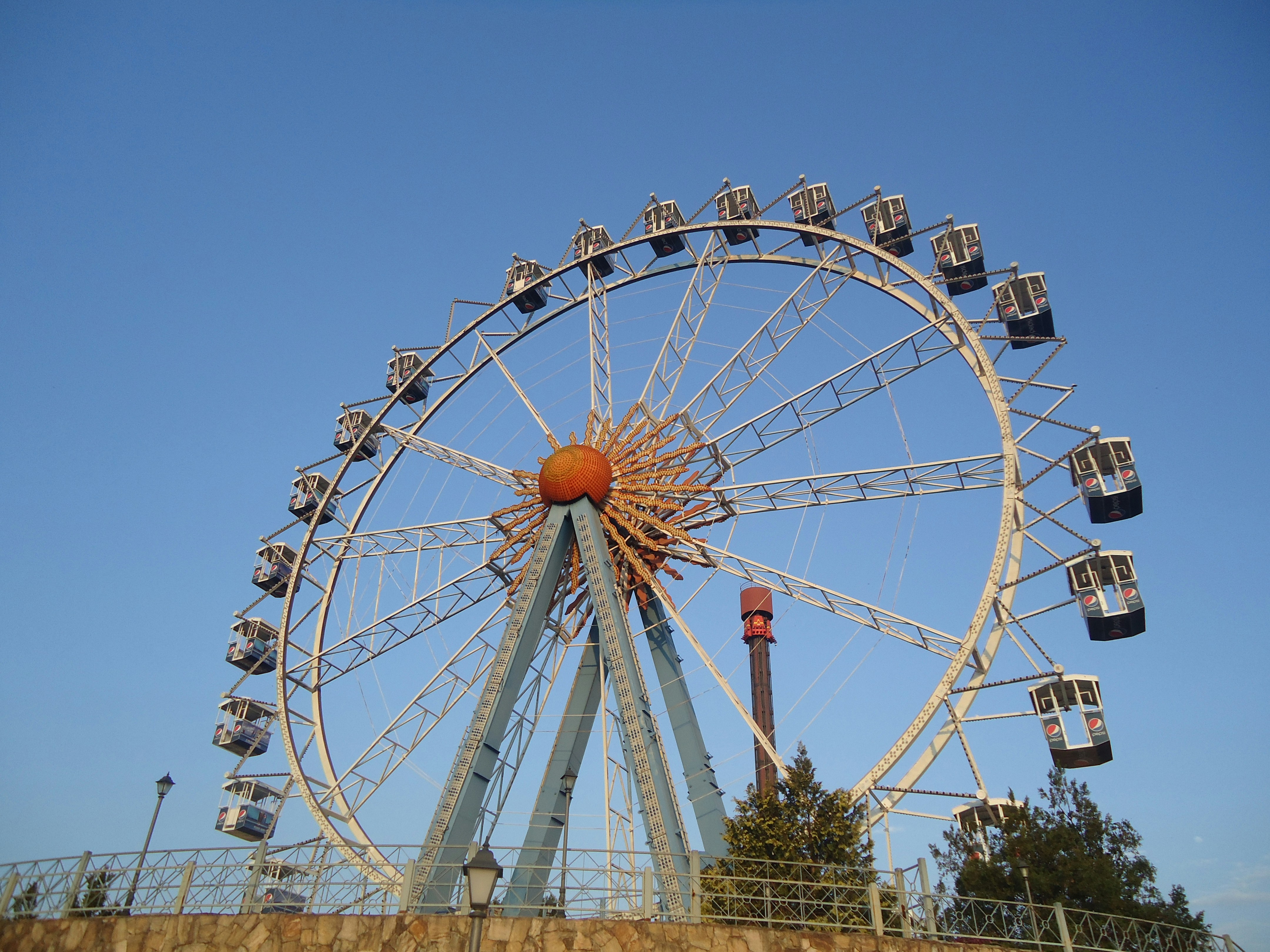 A ferris wheel reaches into a clear, blue sky.
