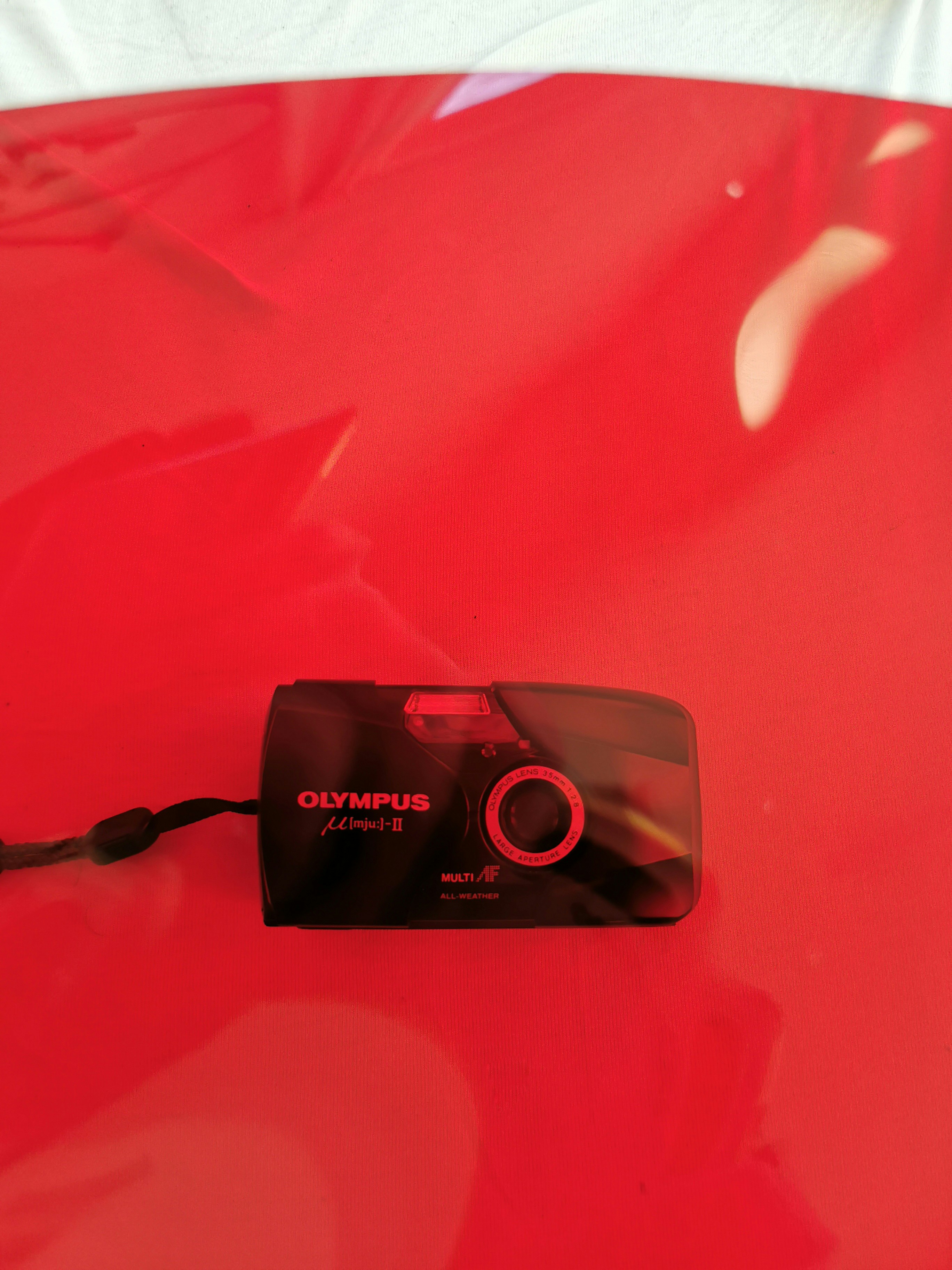 An olympus camera sits on a red surface. photo – Free Camera Image on ...