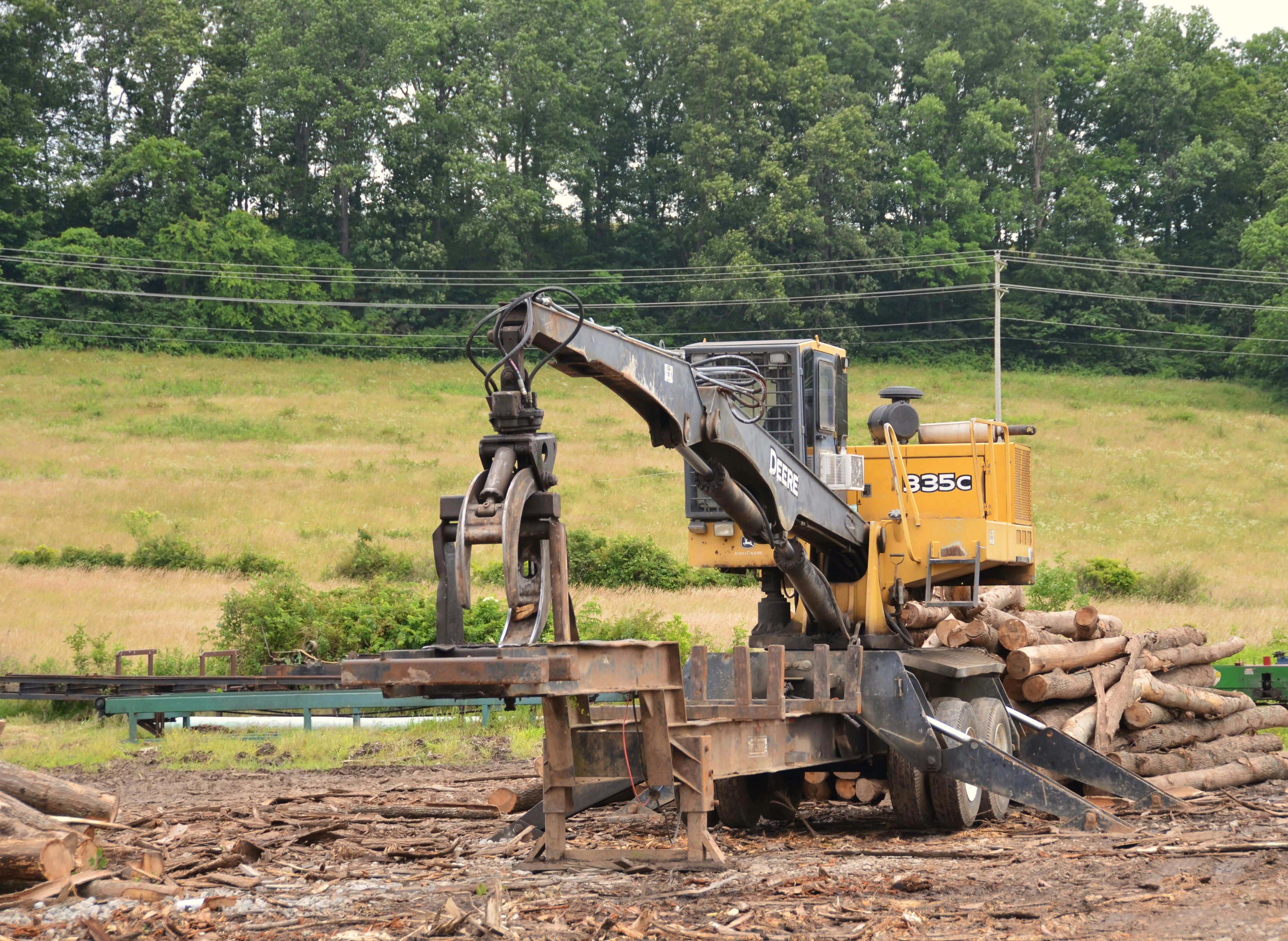 A logging machine is loading logs in a field. photo – Free Wood Image ...