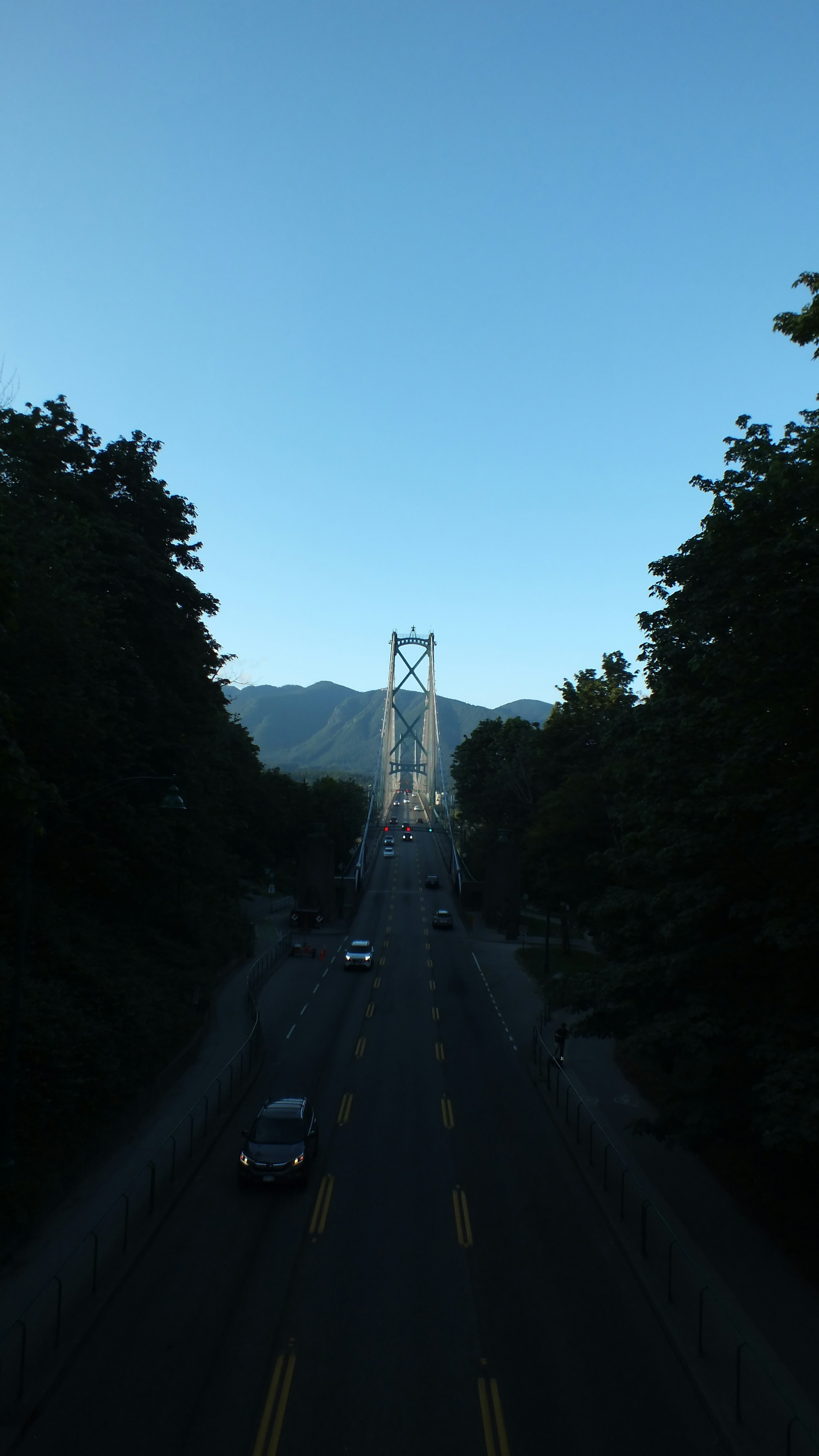 A bridge with cars stretches towards the mountains.
