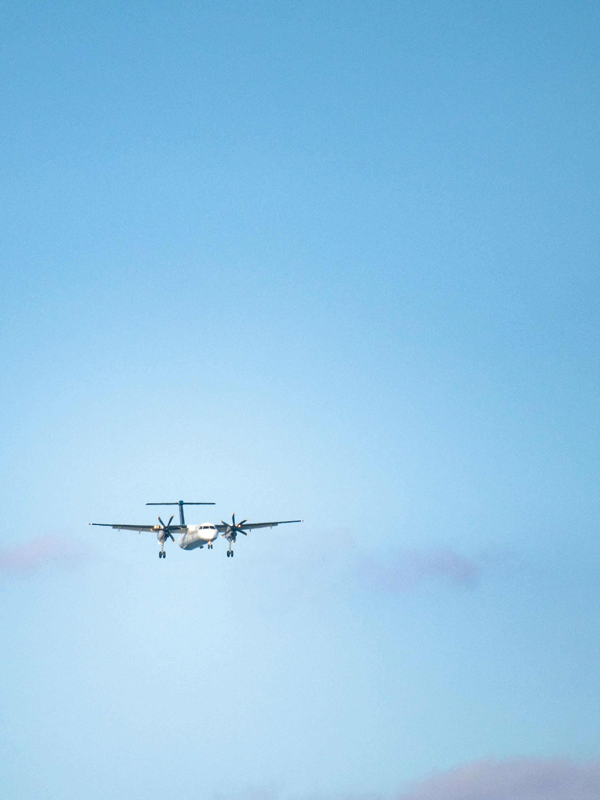 Glide Toward the Camera: A Twin-Prop Aircraft in a Quiet Blue Sky