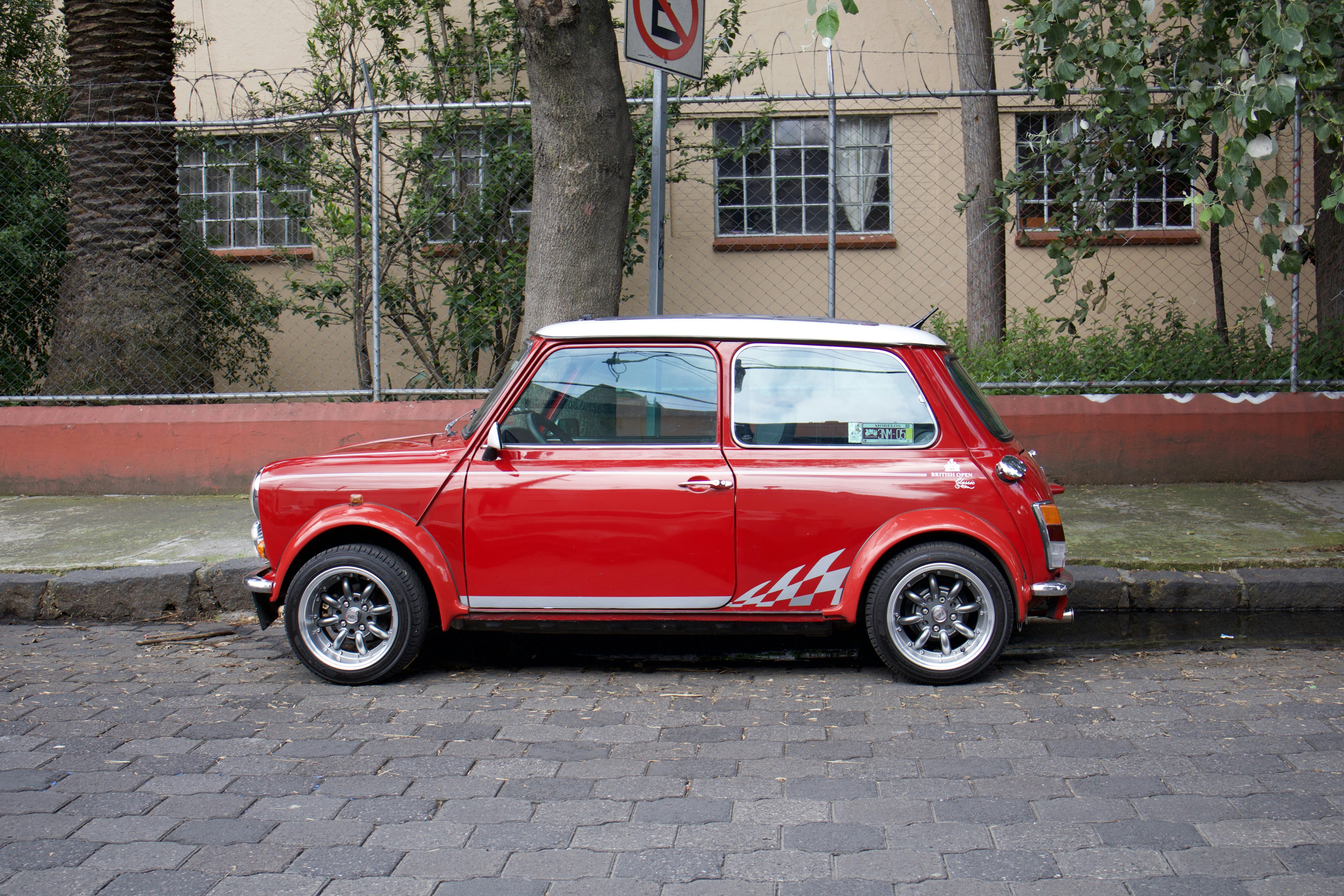 Voici une légende : une mini Cooper rouge est garée dans la rue. photo ...