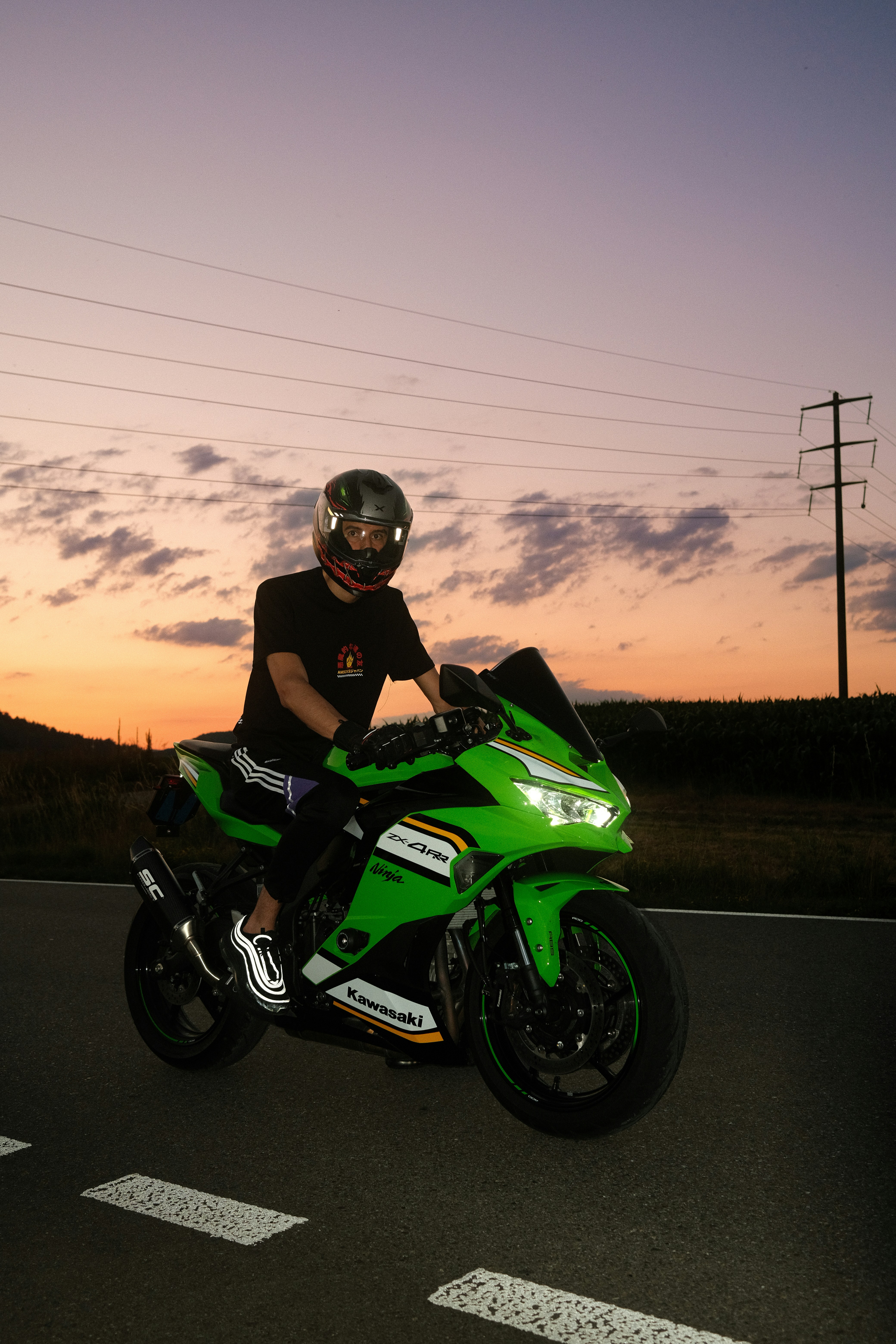 A rider poses on a green sport motorcycle.