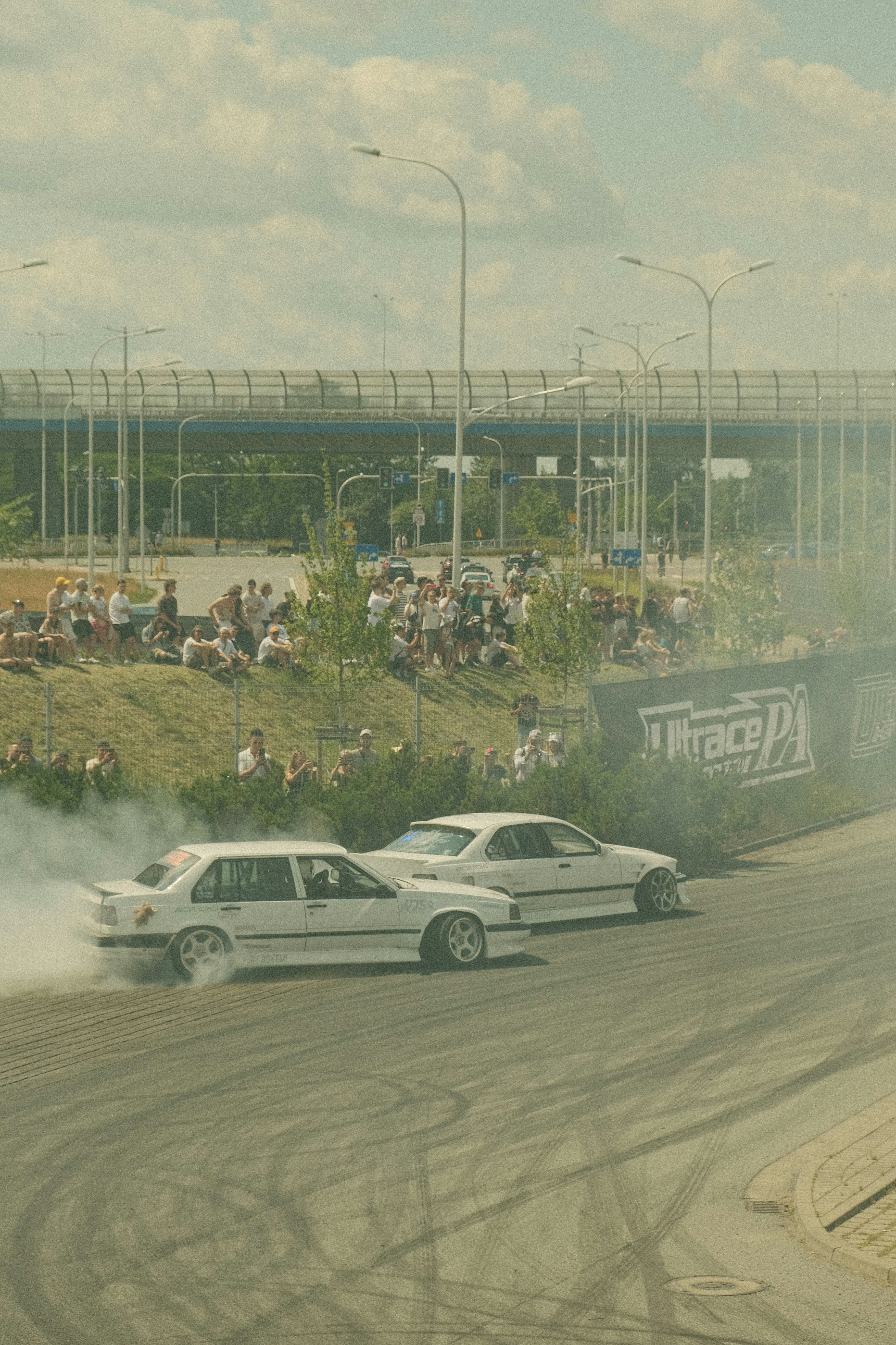 Drift Duel Under Smoke: White Cars Slice the Curve as Fans Watch