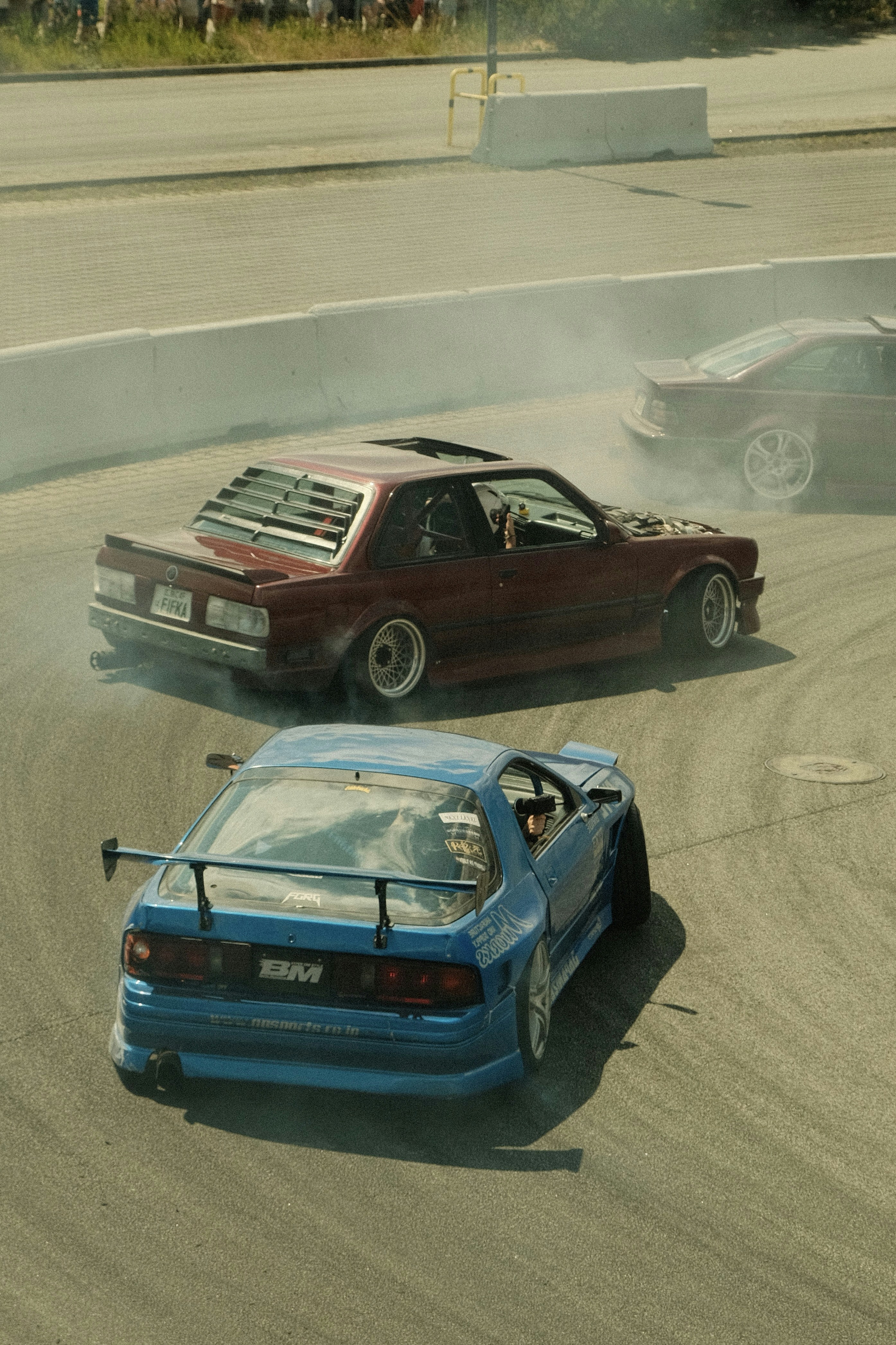 Drifting cars create smoke on a racetrack. photo – Free Car Image on ...