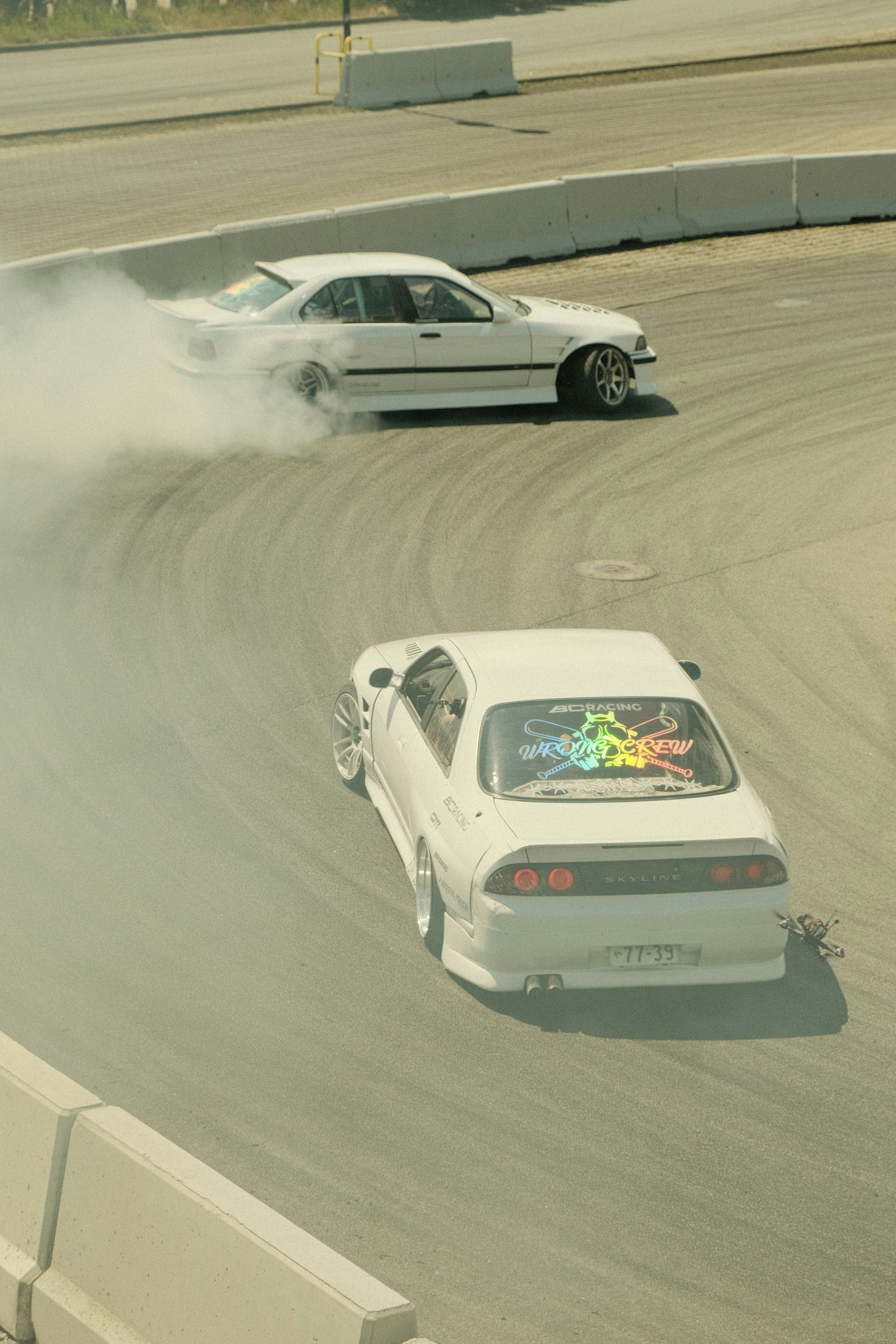Chasing Smoke: White Drift Cars Converge on a Winding Asphalt Drift