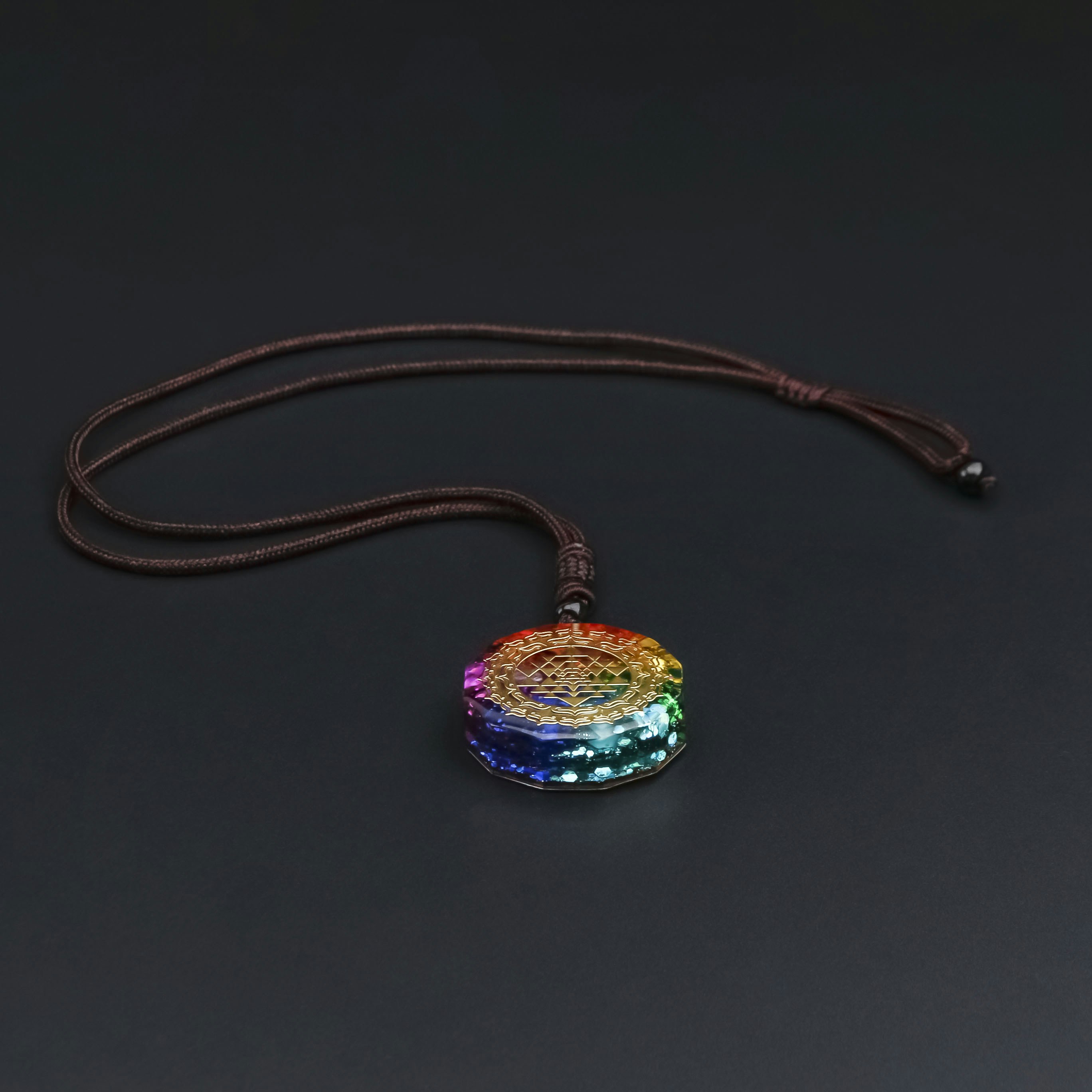 Chakra Orgonite Necklace Balances Energy-Keekon | A rainbow-colored pendant is shown hanging.