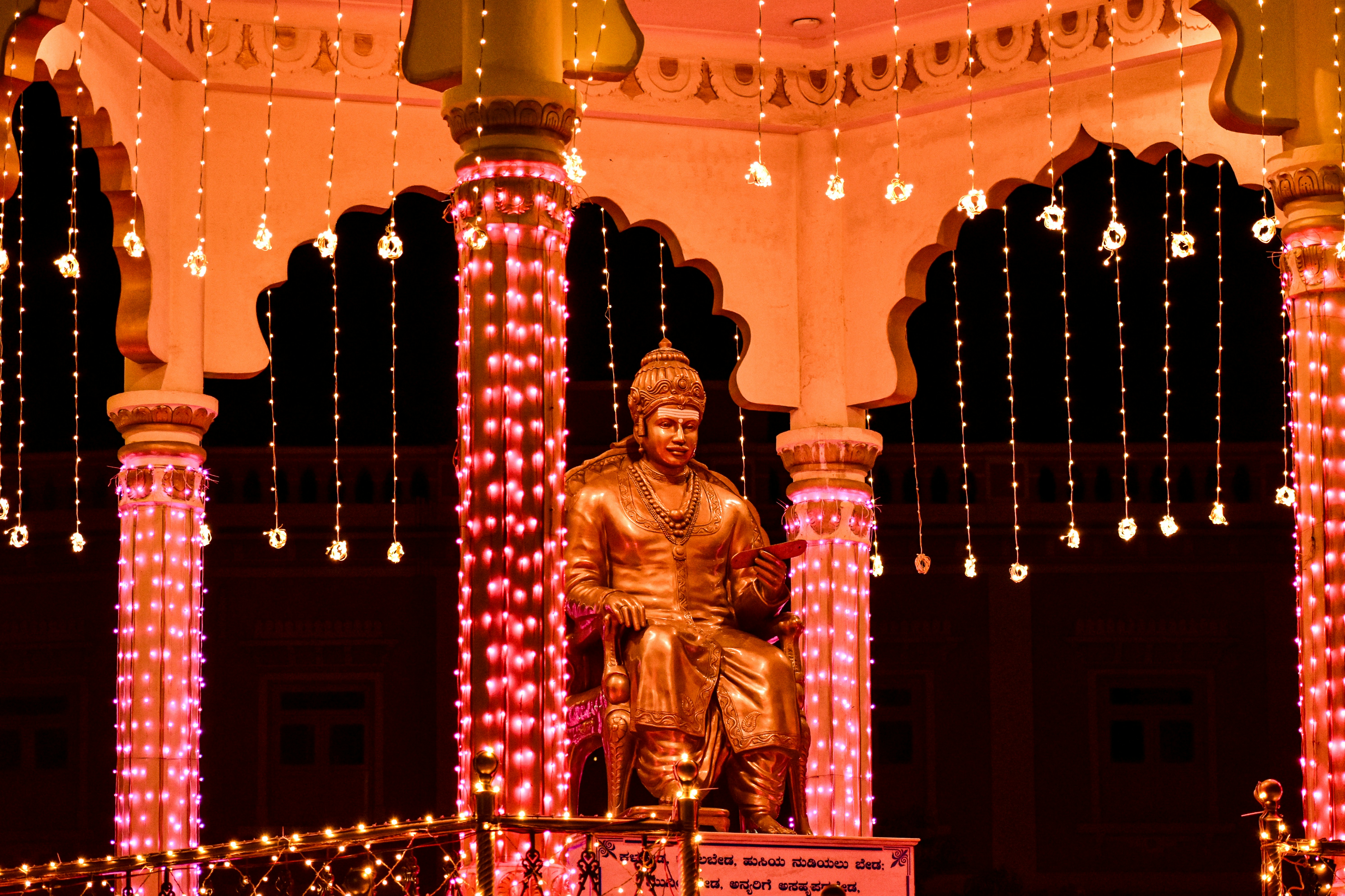 A lit statue of a man is center stage.