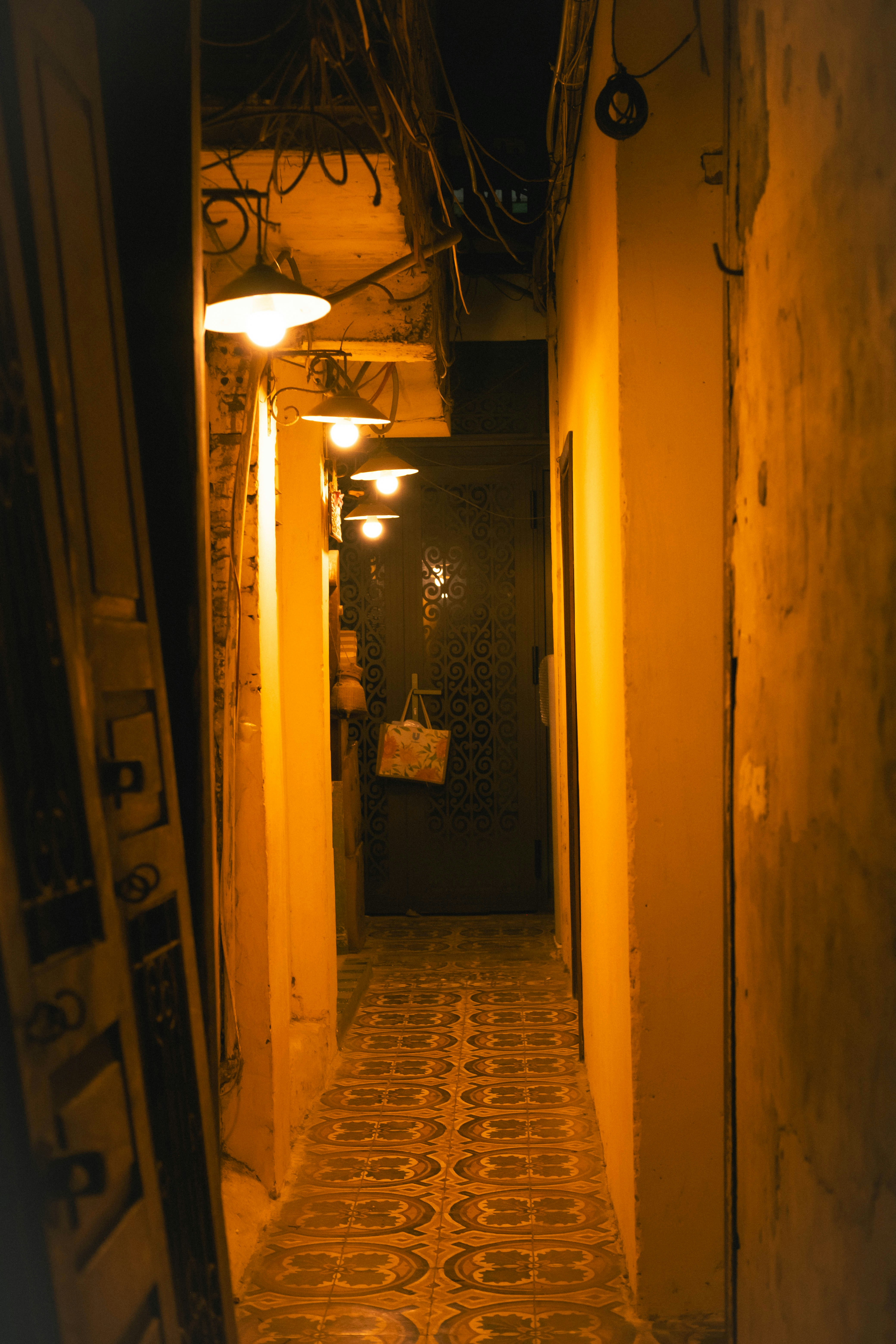 A narrow alley illuminated by overhead lights.