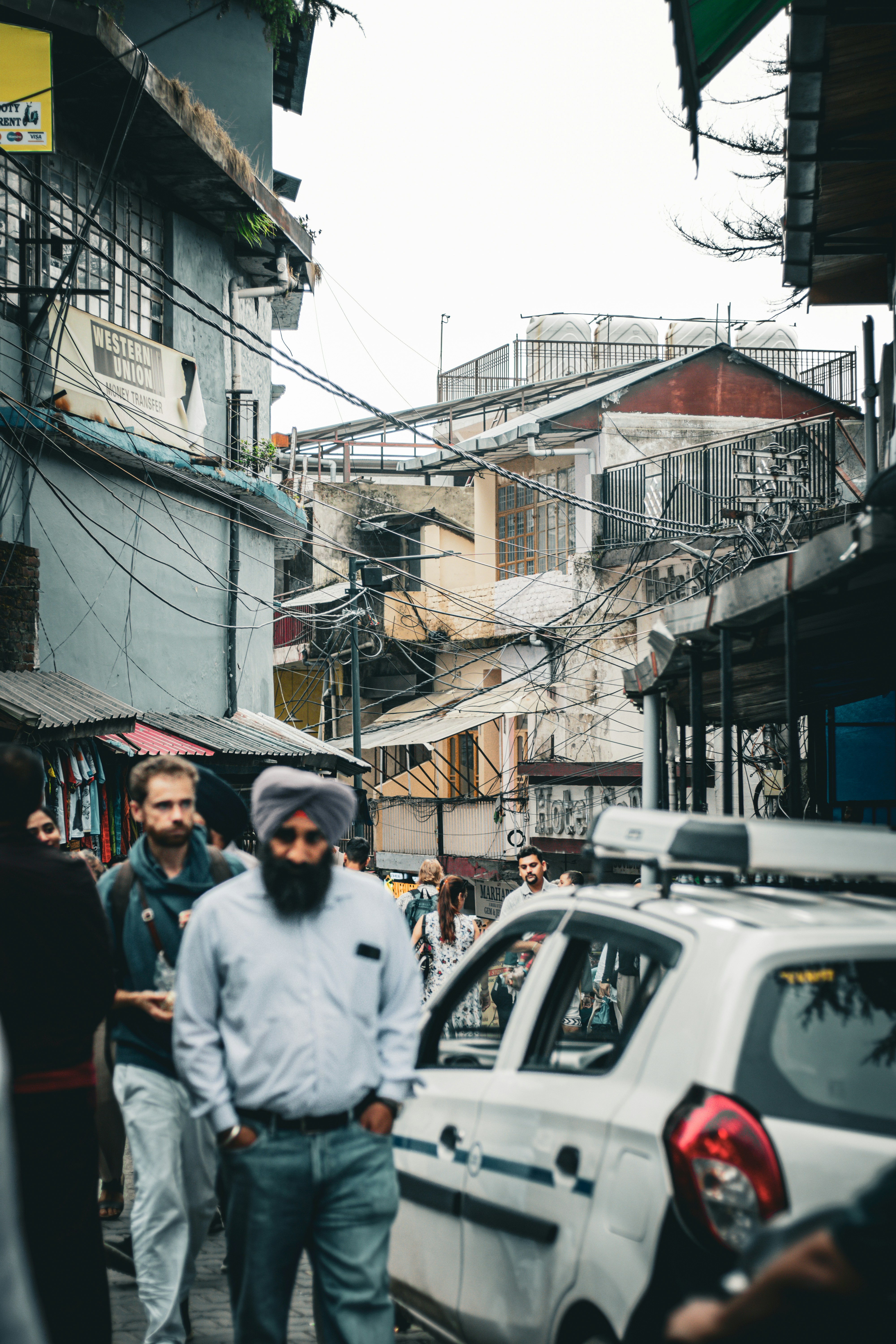 People walk down a busy street in a city.
