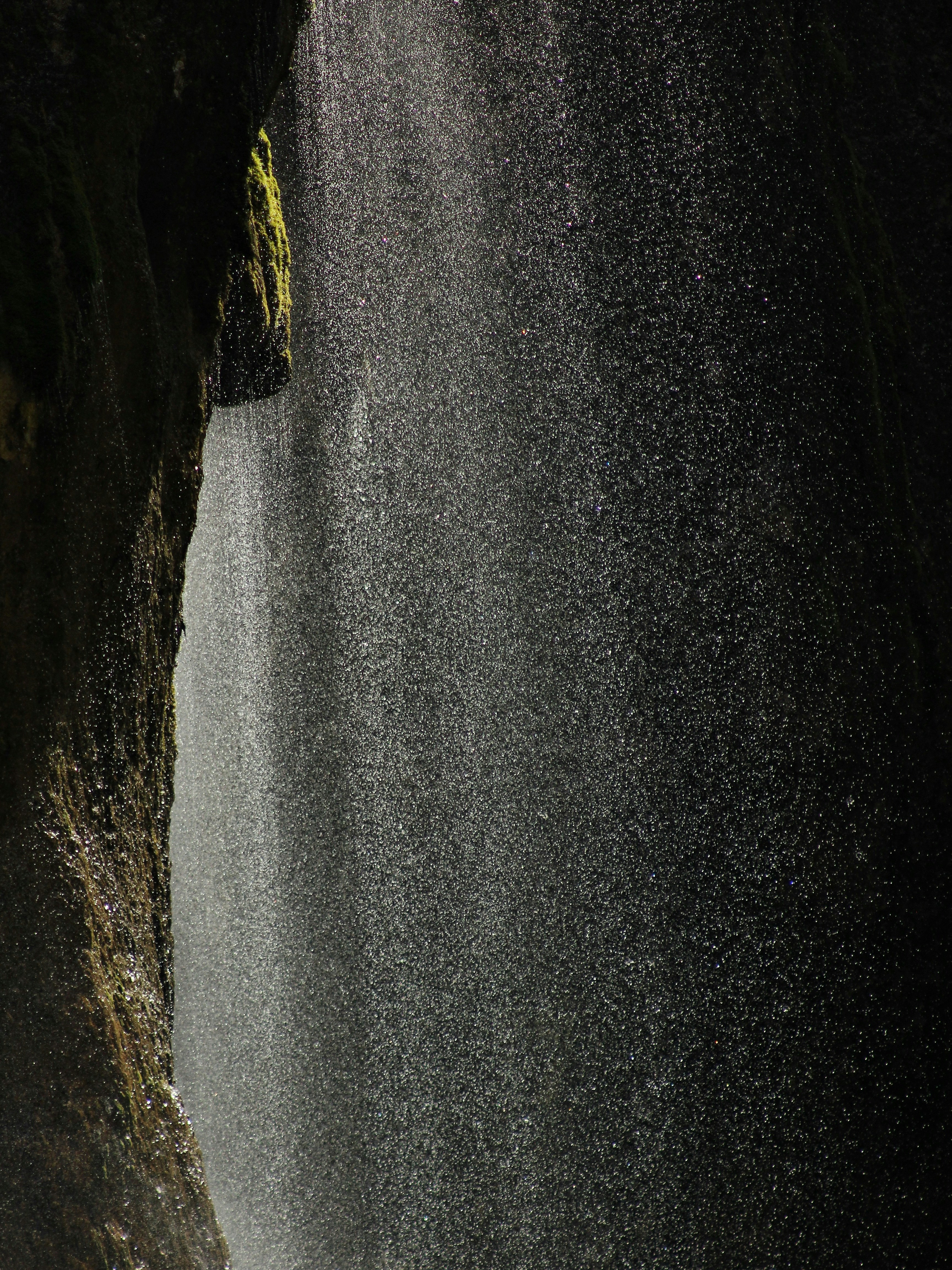 Water cascading down a rocky cliff, creating a misty veil that catches the light beautifully.