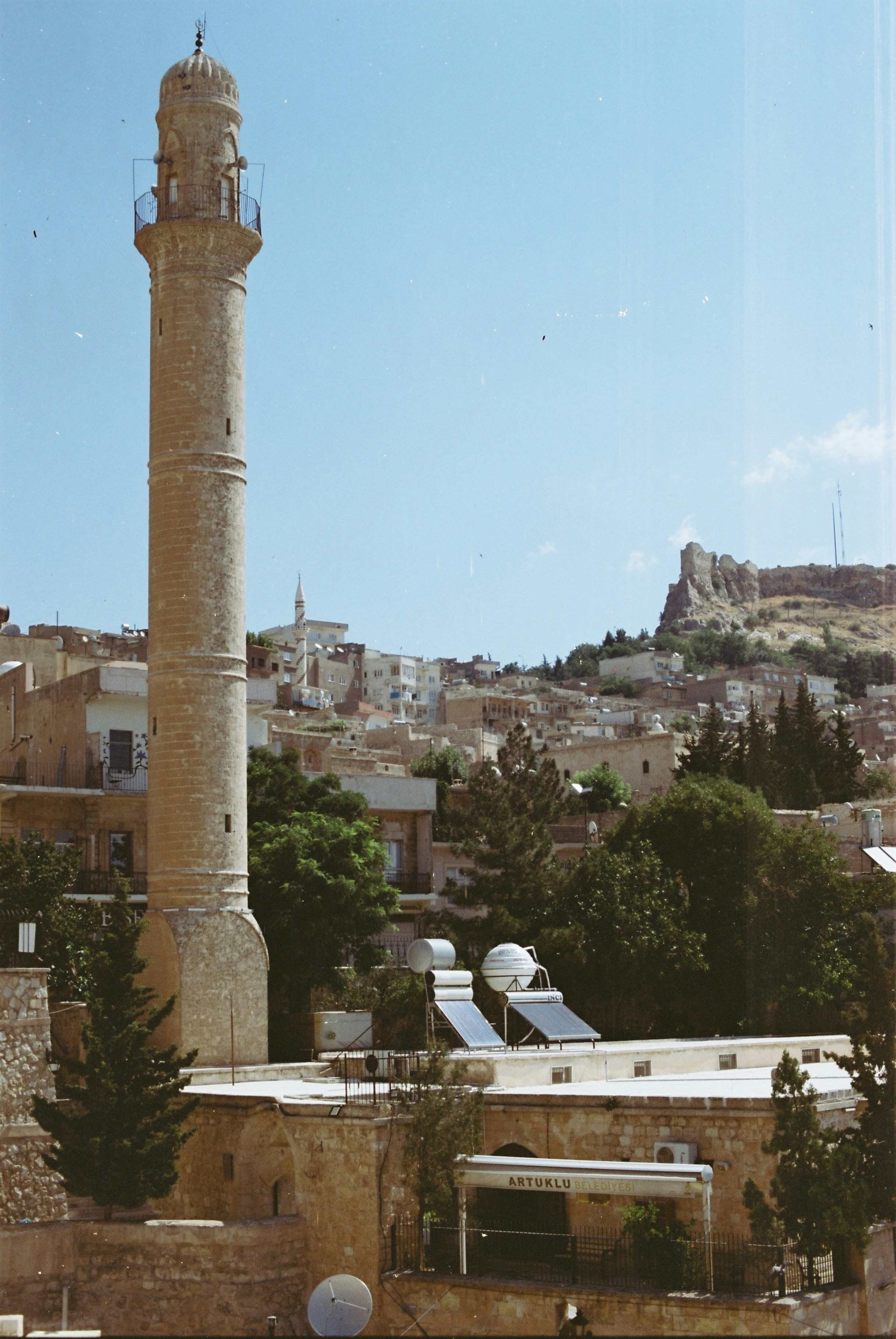 A tall minaret stands above a cityscape.