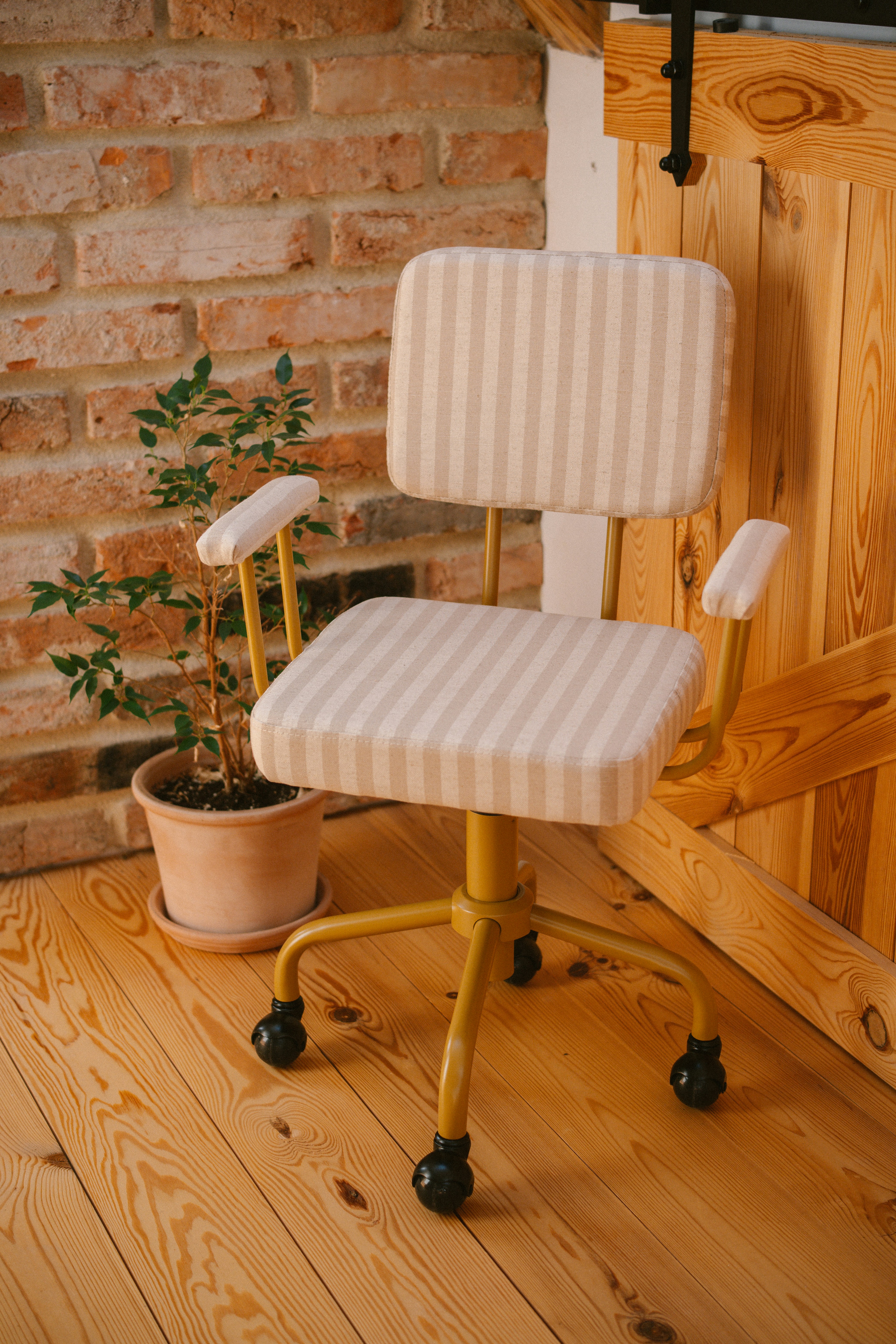Nestled Workspace: a striped adjustable chair in a sunlit corner