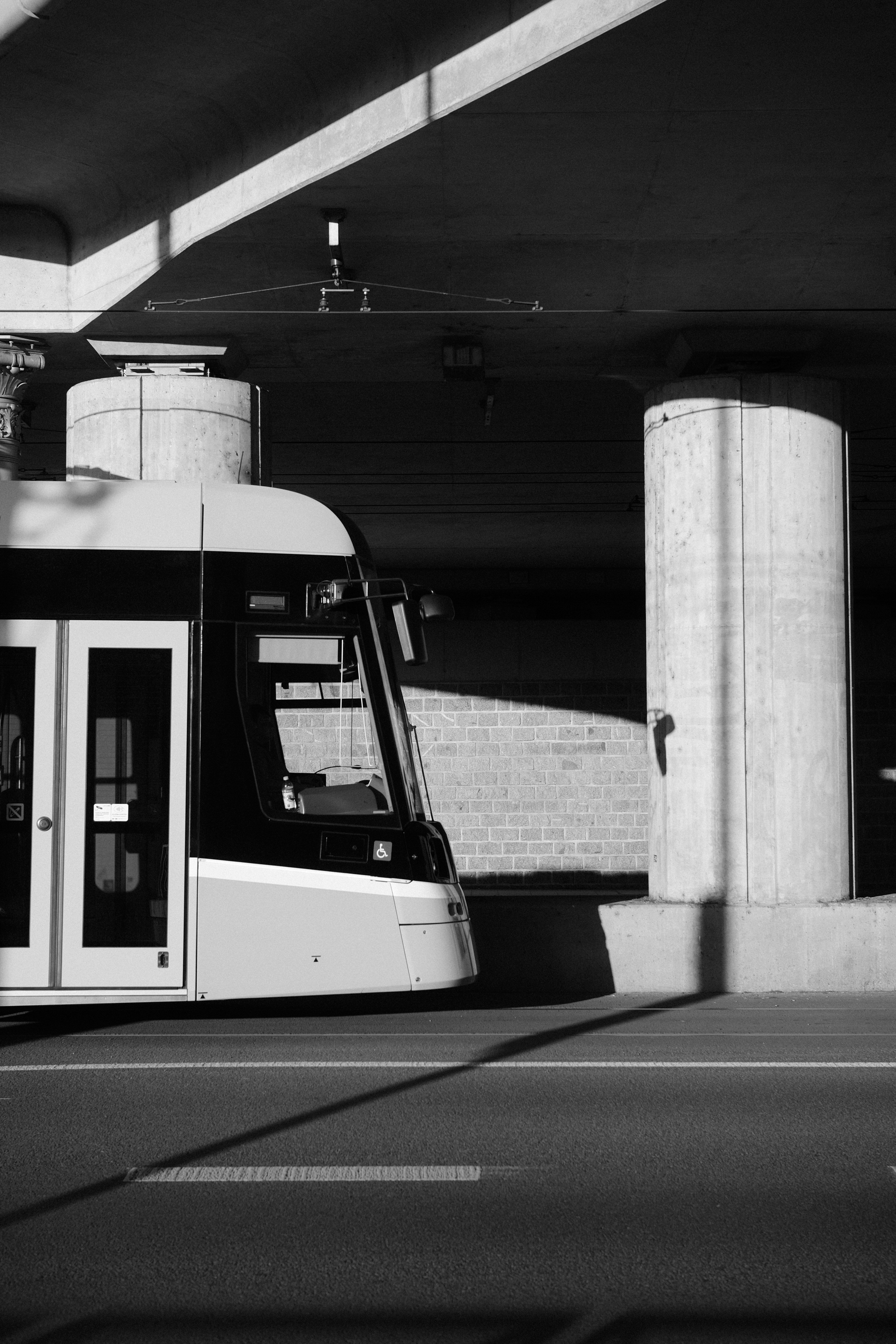 A train waits underneath a concrete structure. photo – Free Travel ...