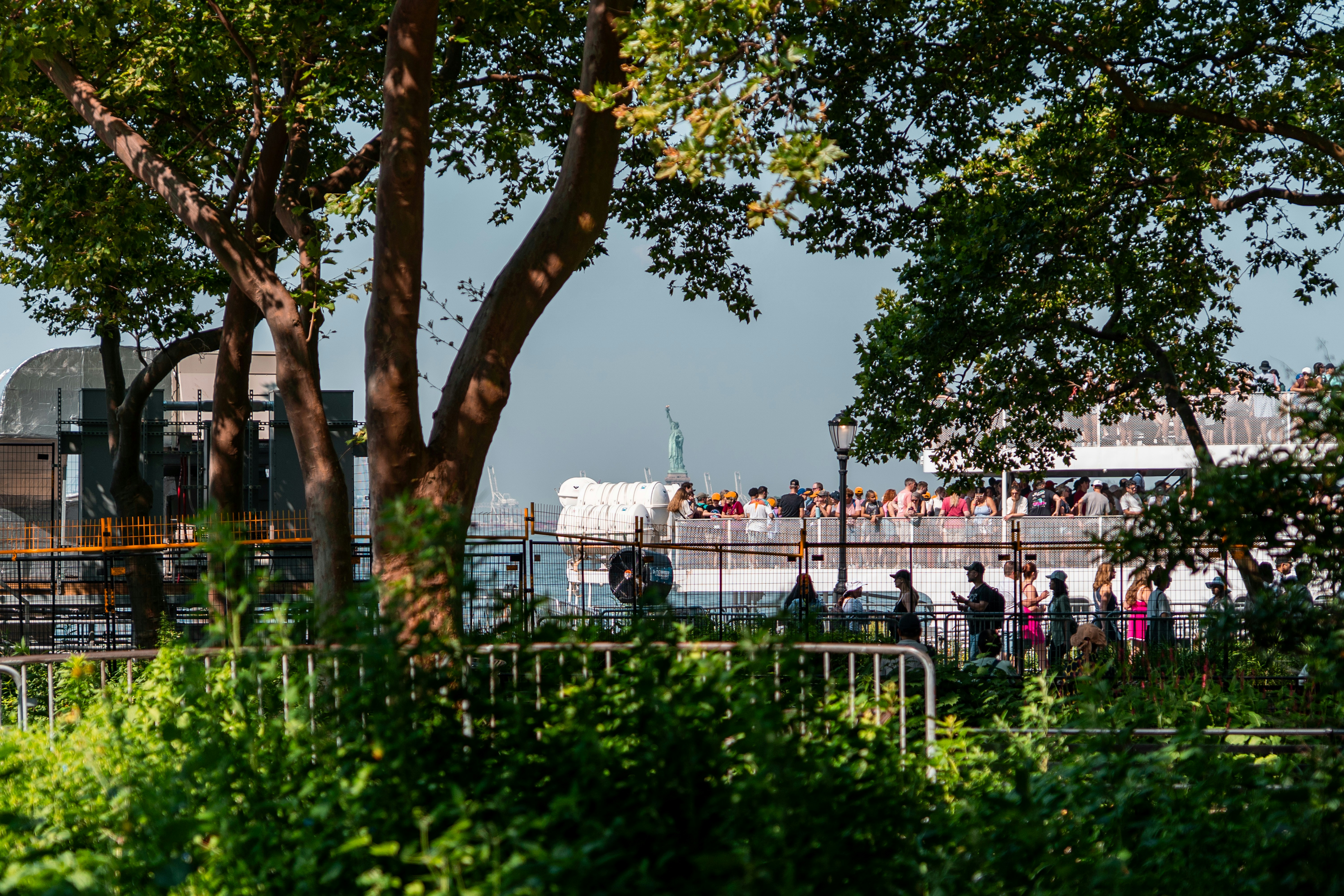 Crowd on a Sunny Pier Beneath Shaded Trees