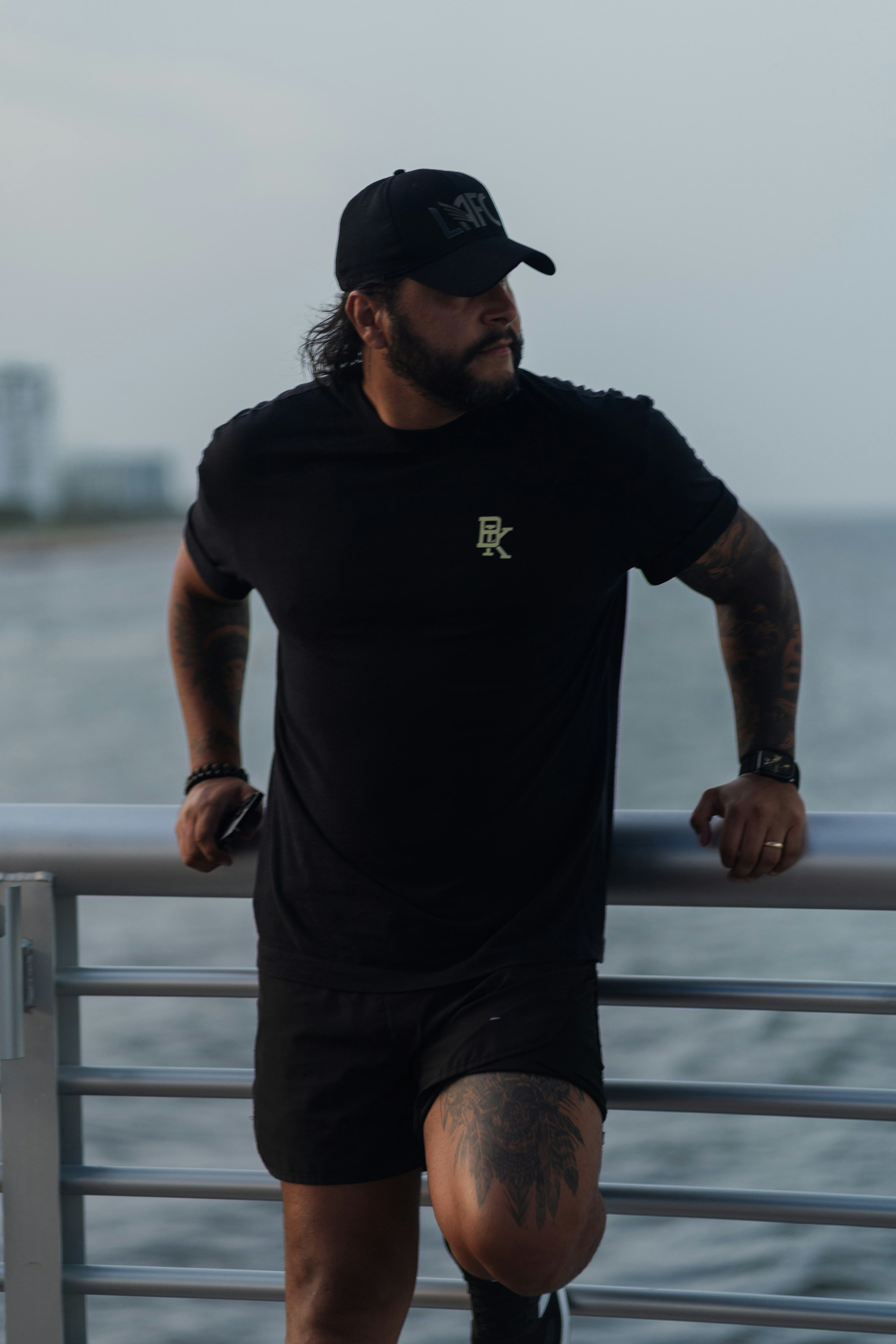 Man poses on a pier, gazing away.