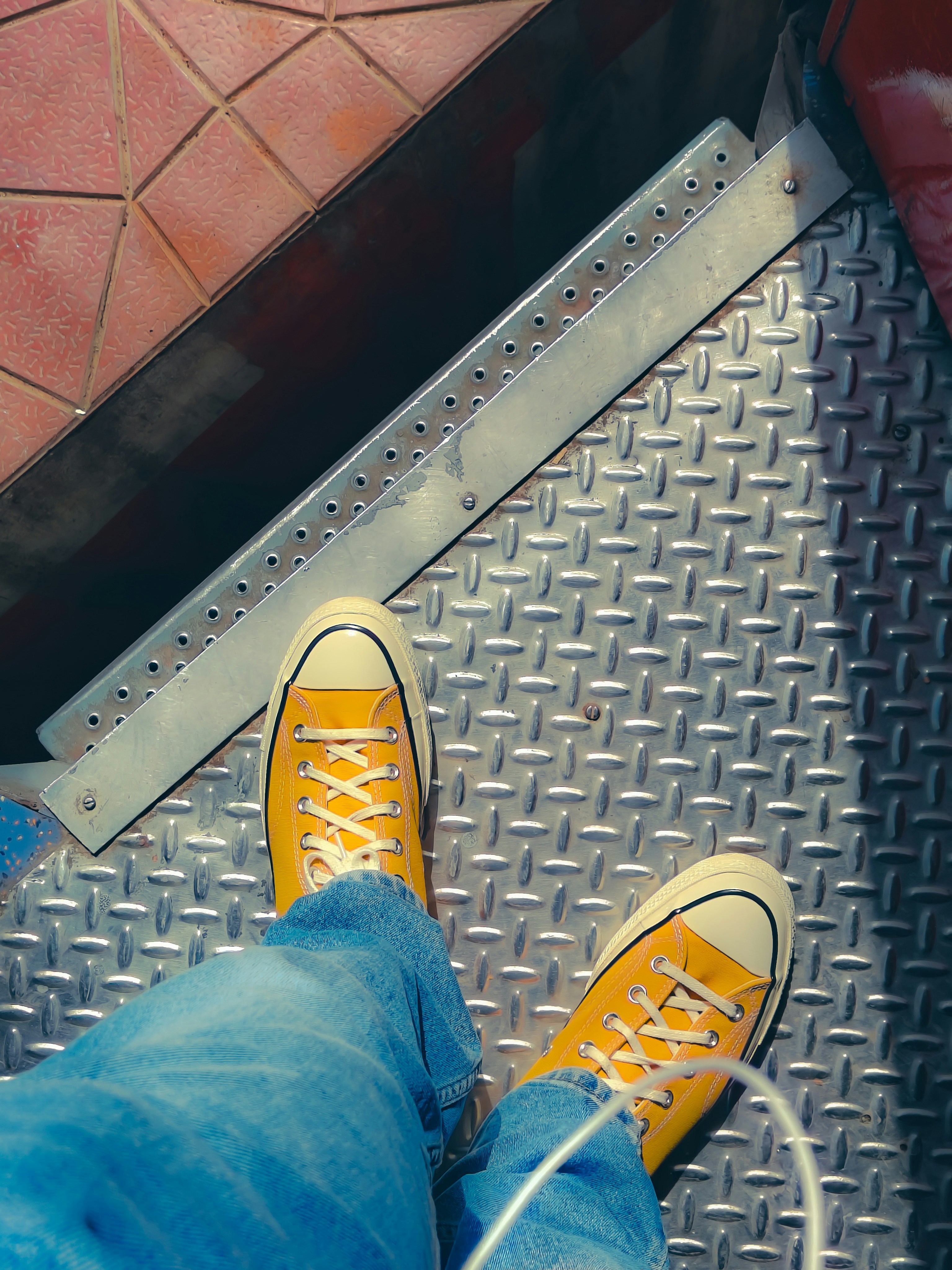 Chukin' my way! | Yellow sneakers stand on a metal stair.