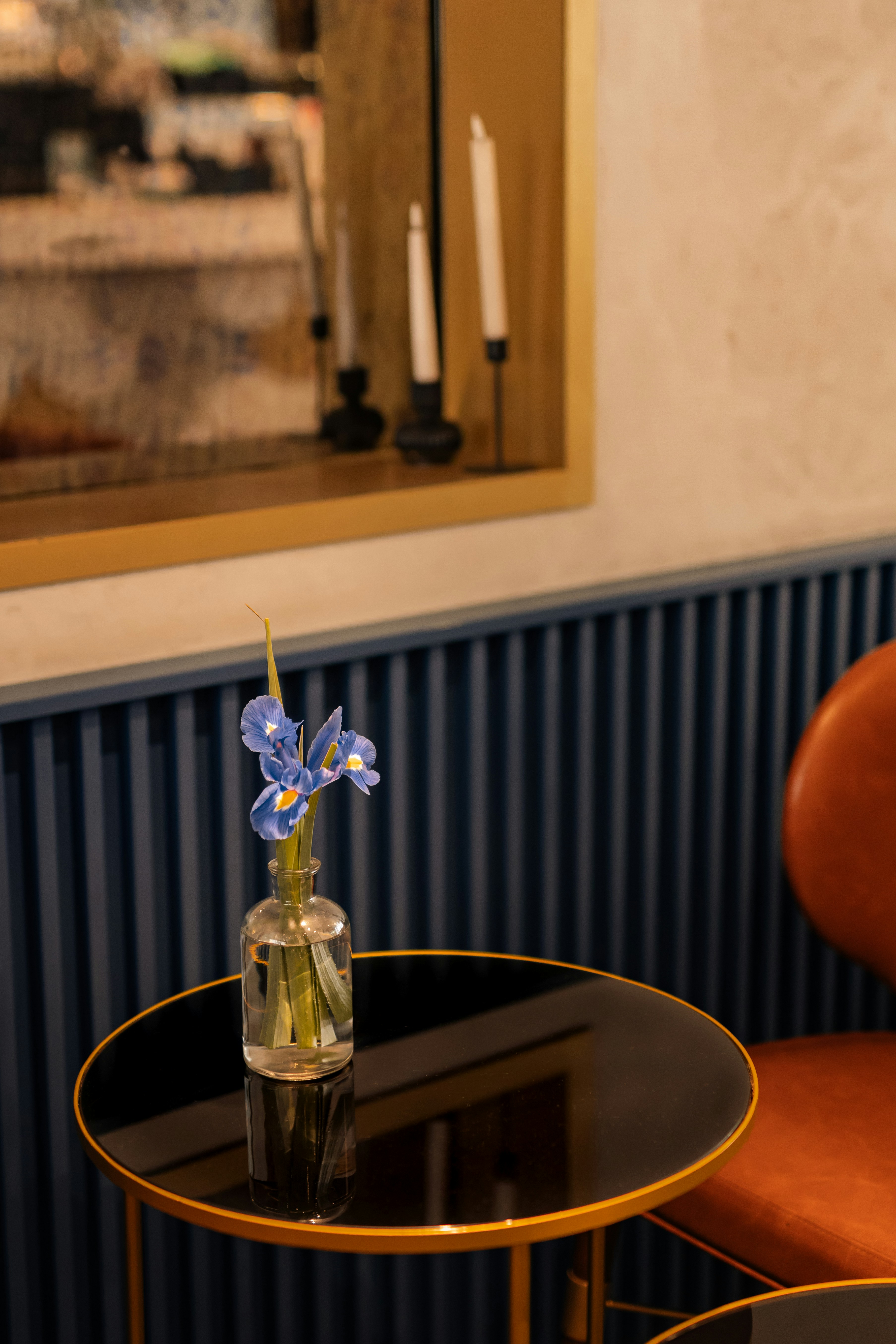 A blue flower sits on a small, black table.