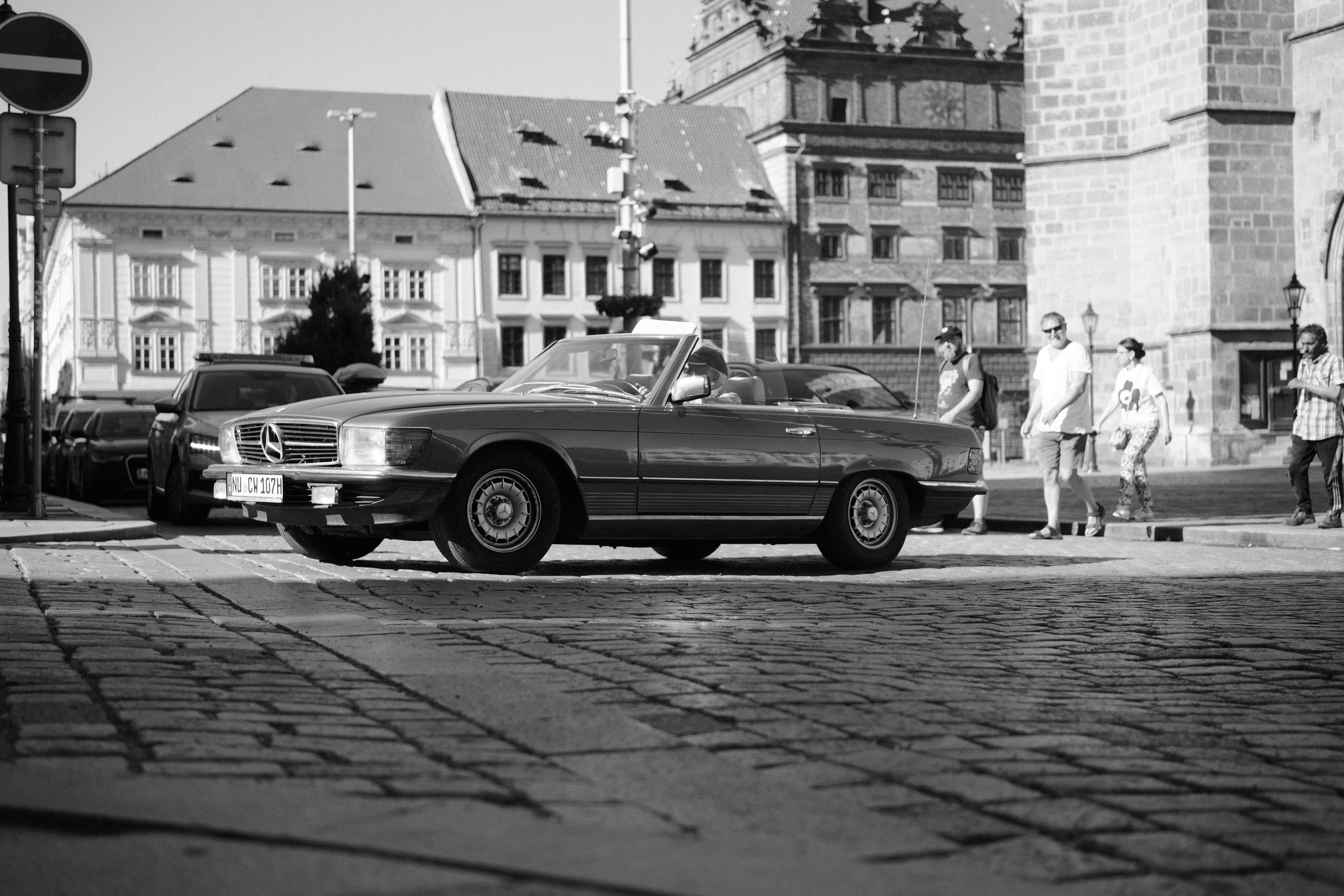 Mercedes-Benz 450 SL. Classic car driving past historic buildings in city