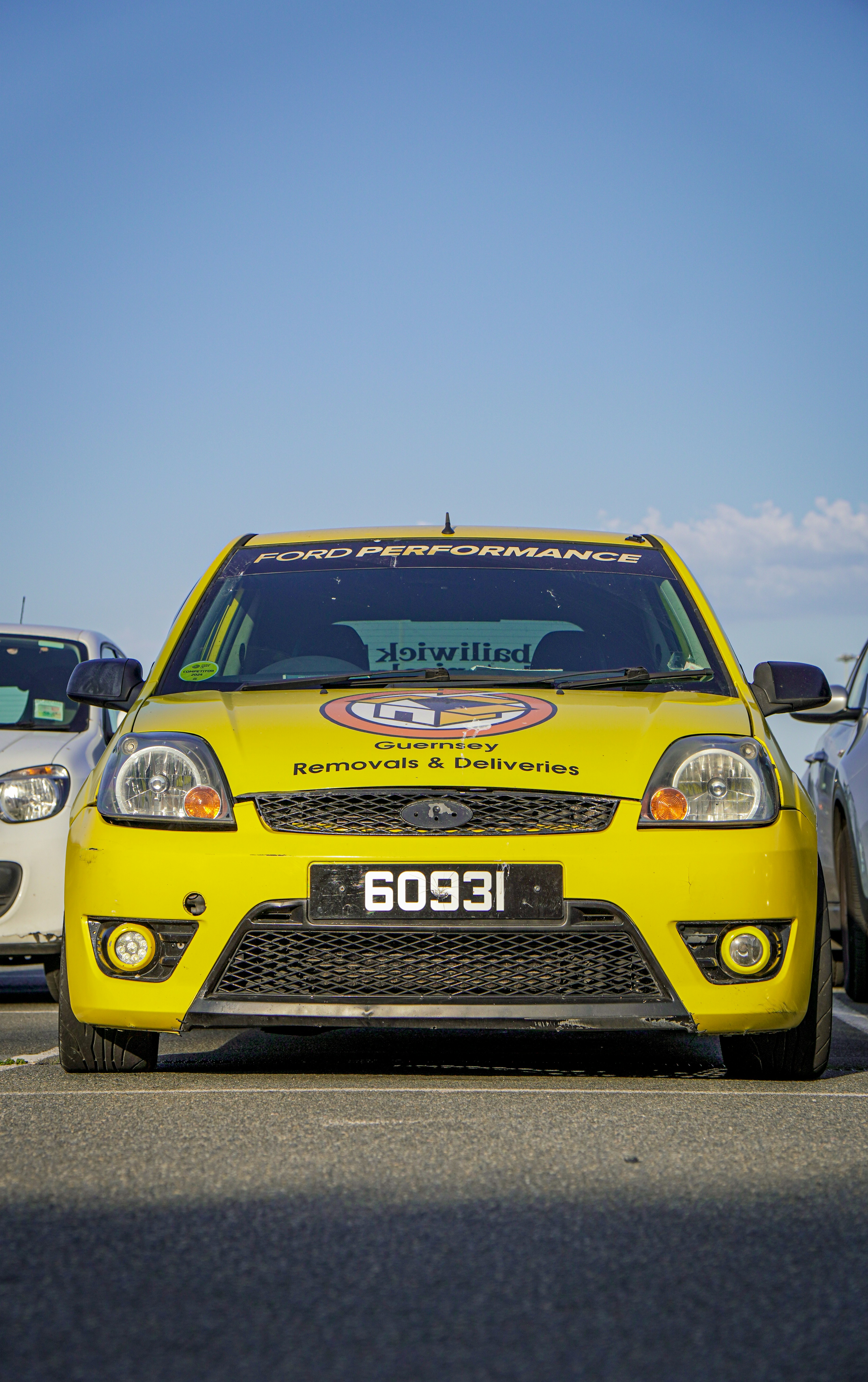 A bright yellow car is parked in a parking lot. photo – Free Car Image ...