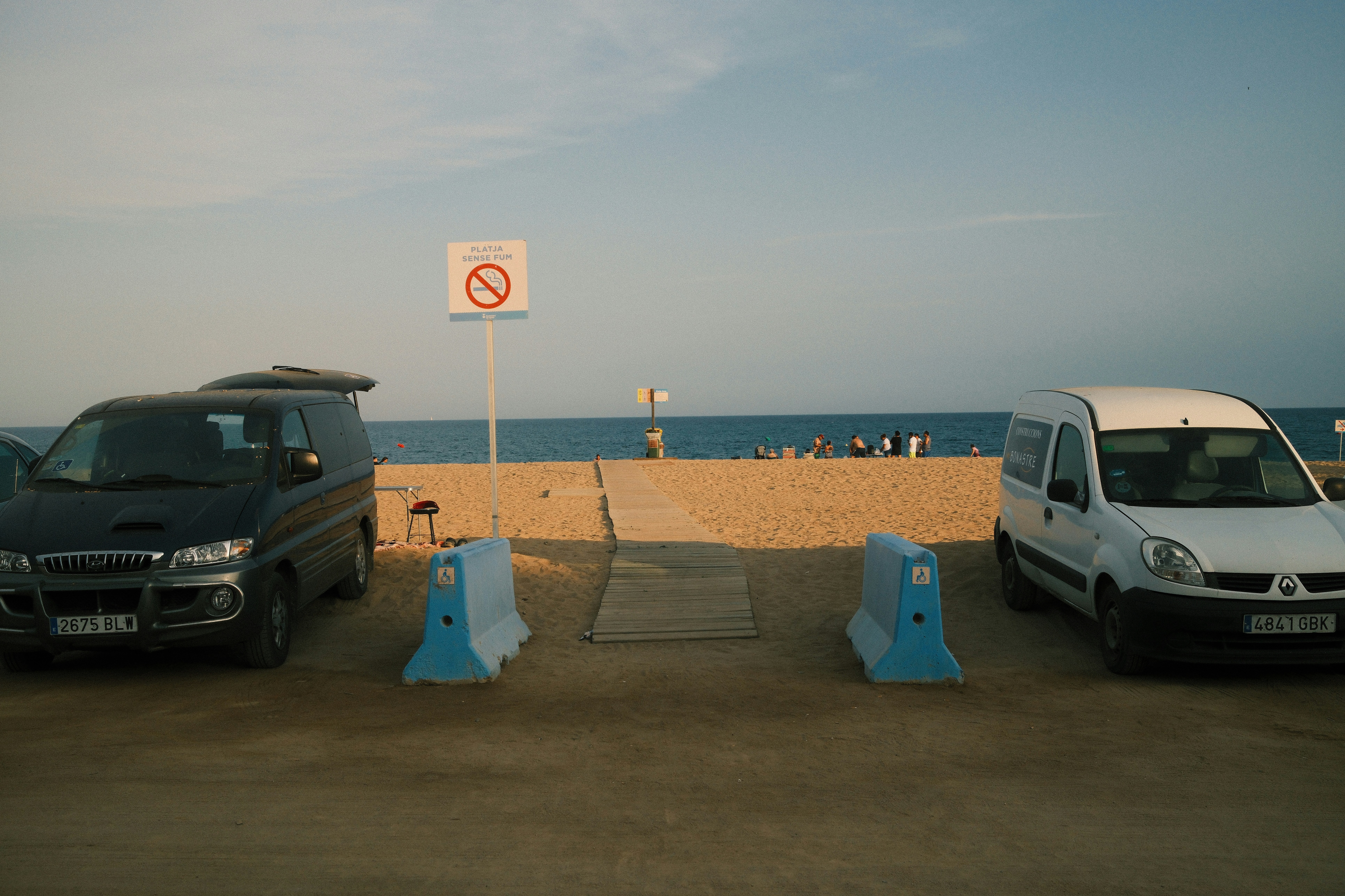 Framed Path to the Sea: Vans flanking a Beach Entrance