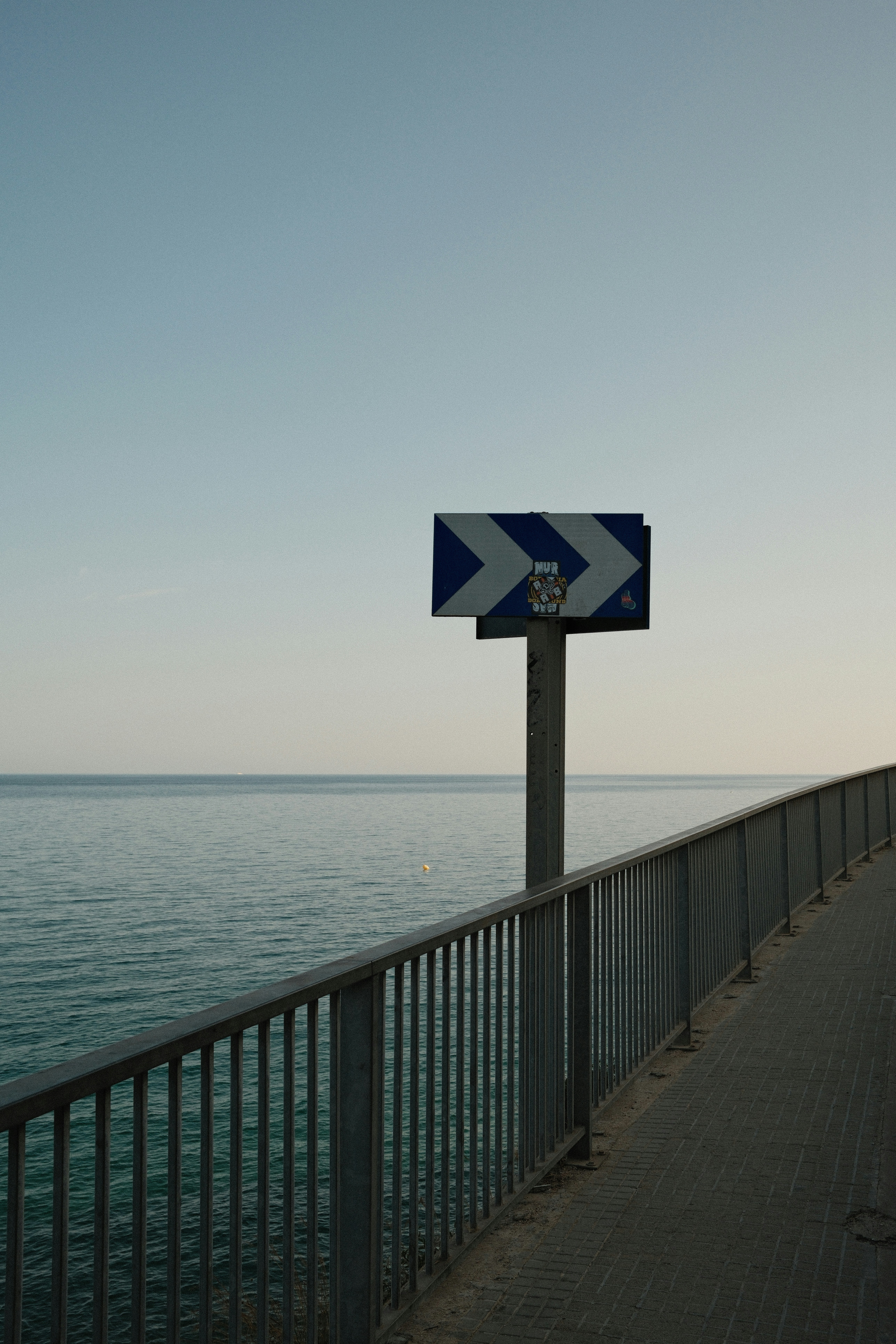 Coastline Signal: A Quiet Pier Meets A Silent Highway Sign