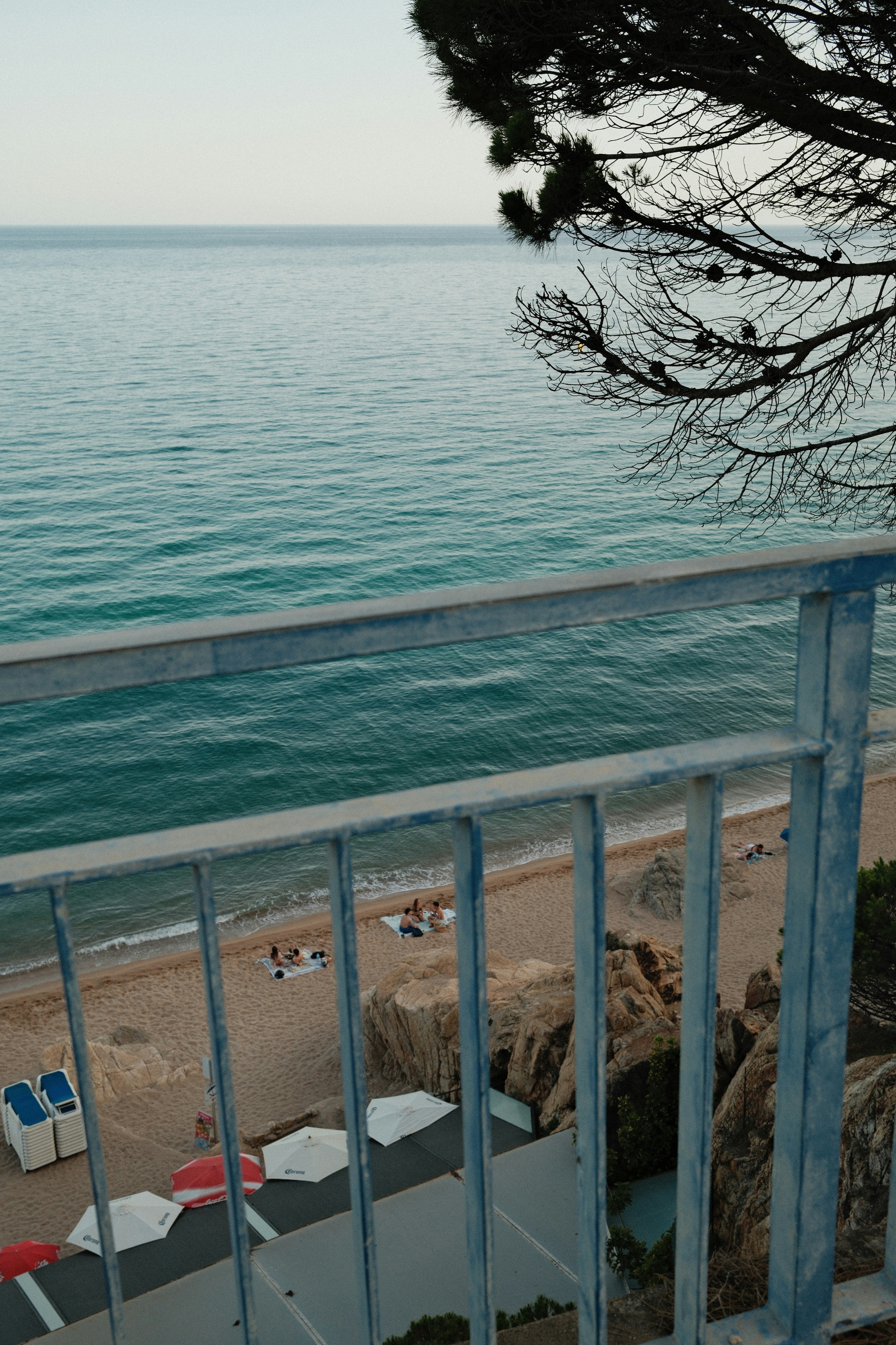 Framed by Weathered Rails, a Teal Sea Meets a Quiet Beach