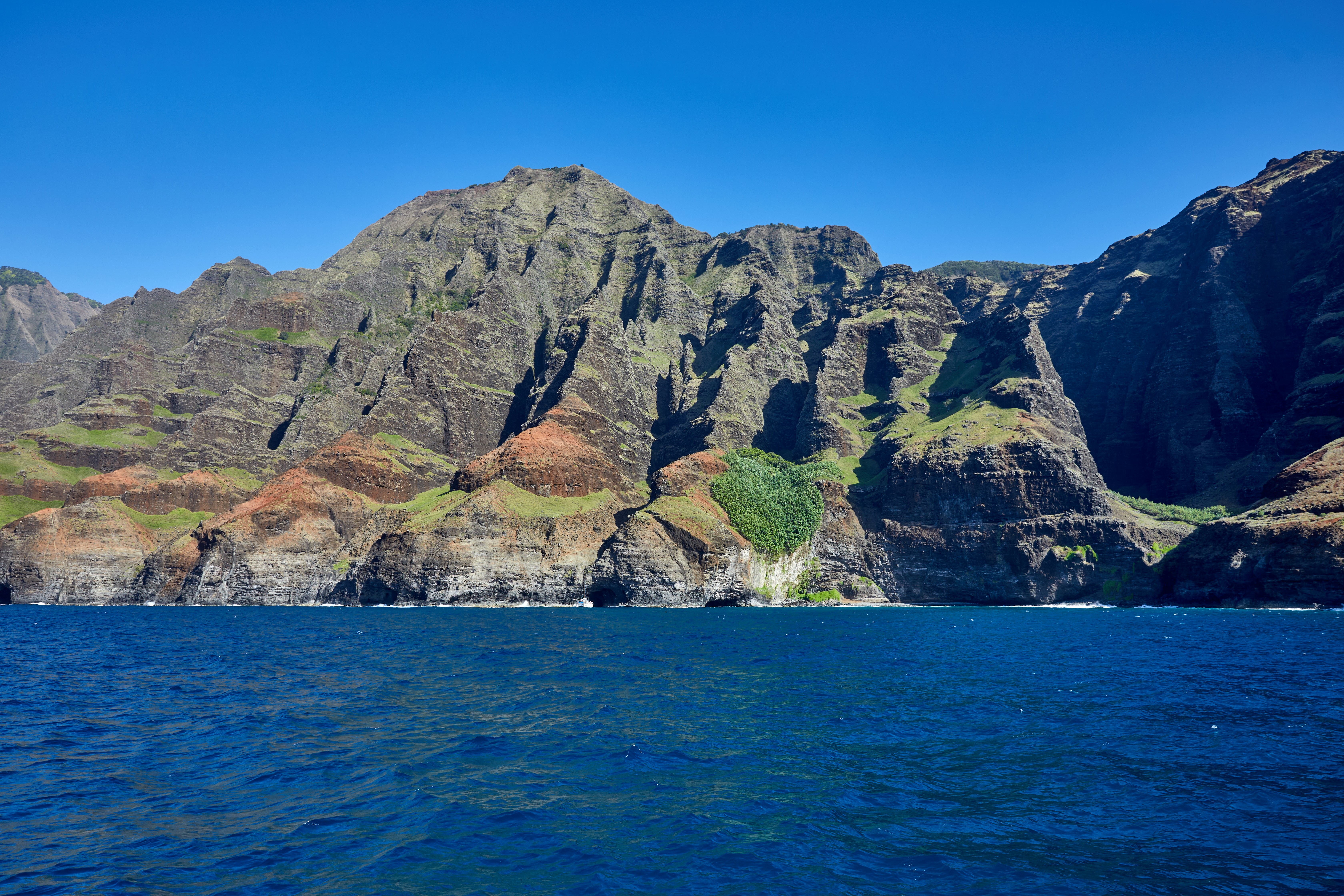 Rocky cliffs rise from the ocean's blue waters.