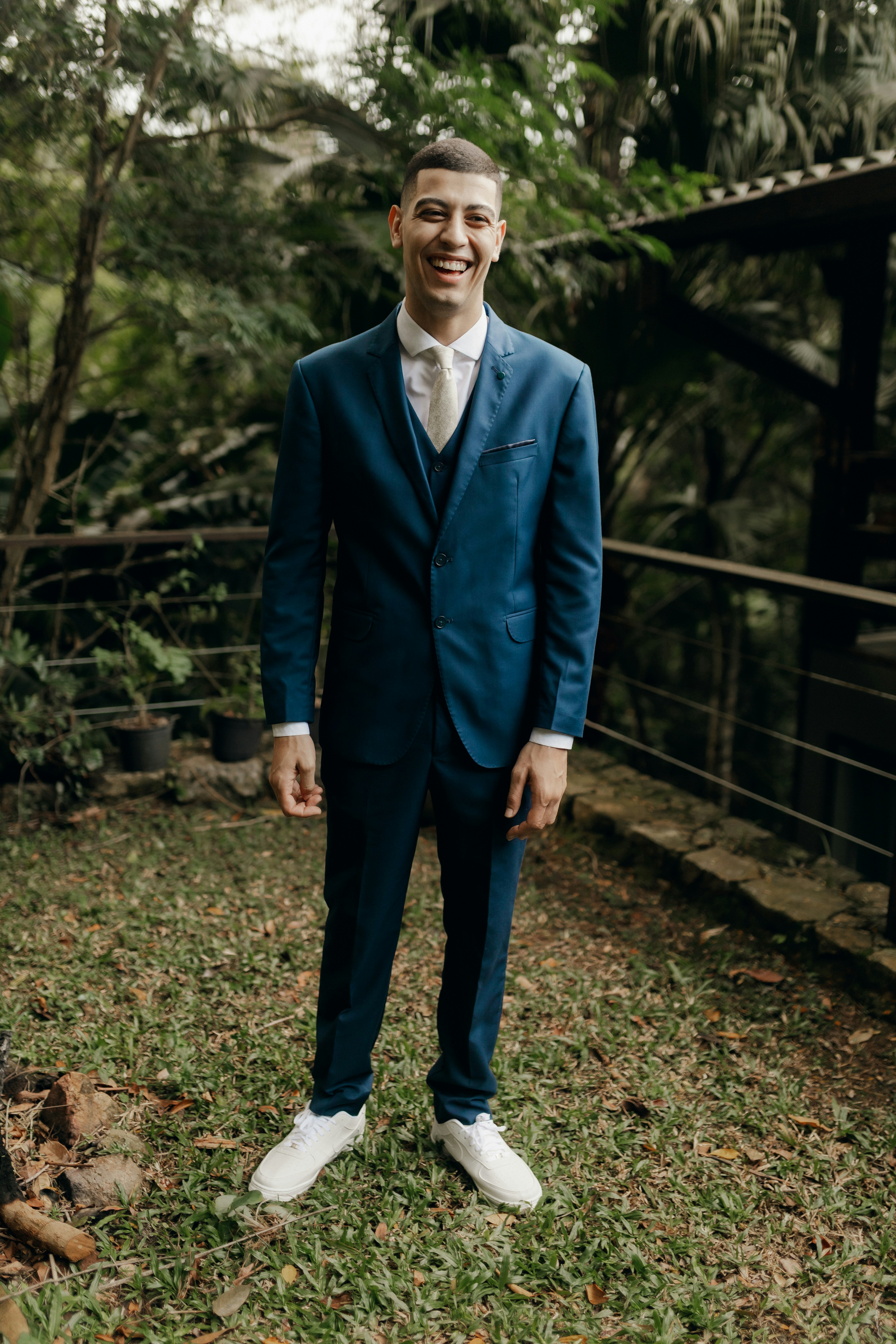 Man in a suit smiles brightly at the camera.