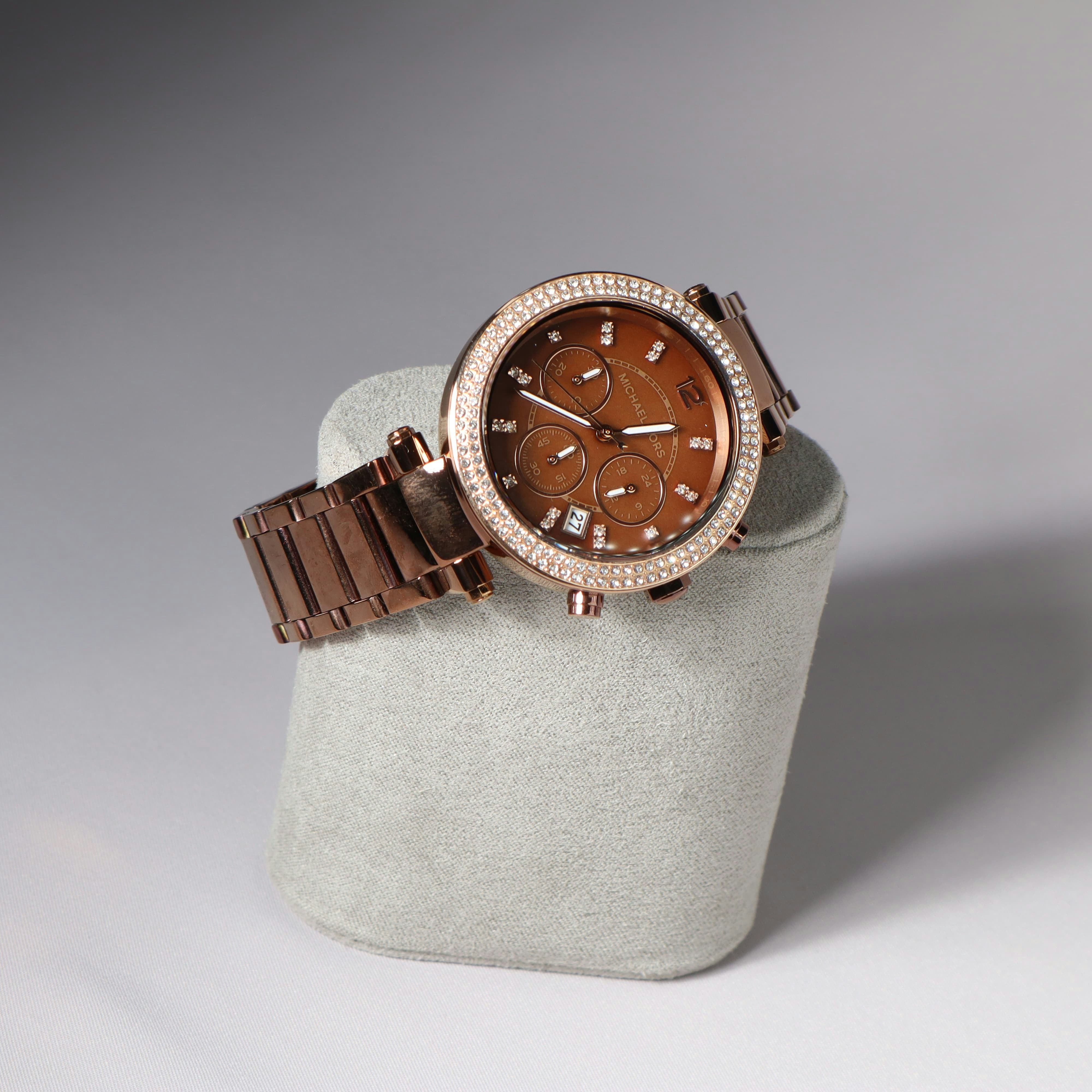 A stylish rose gold watch rests on a display. photo – Free Watch Image ...