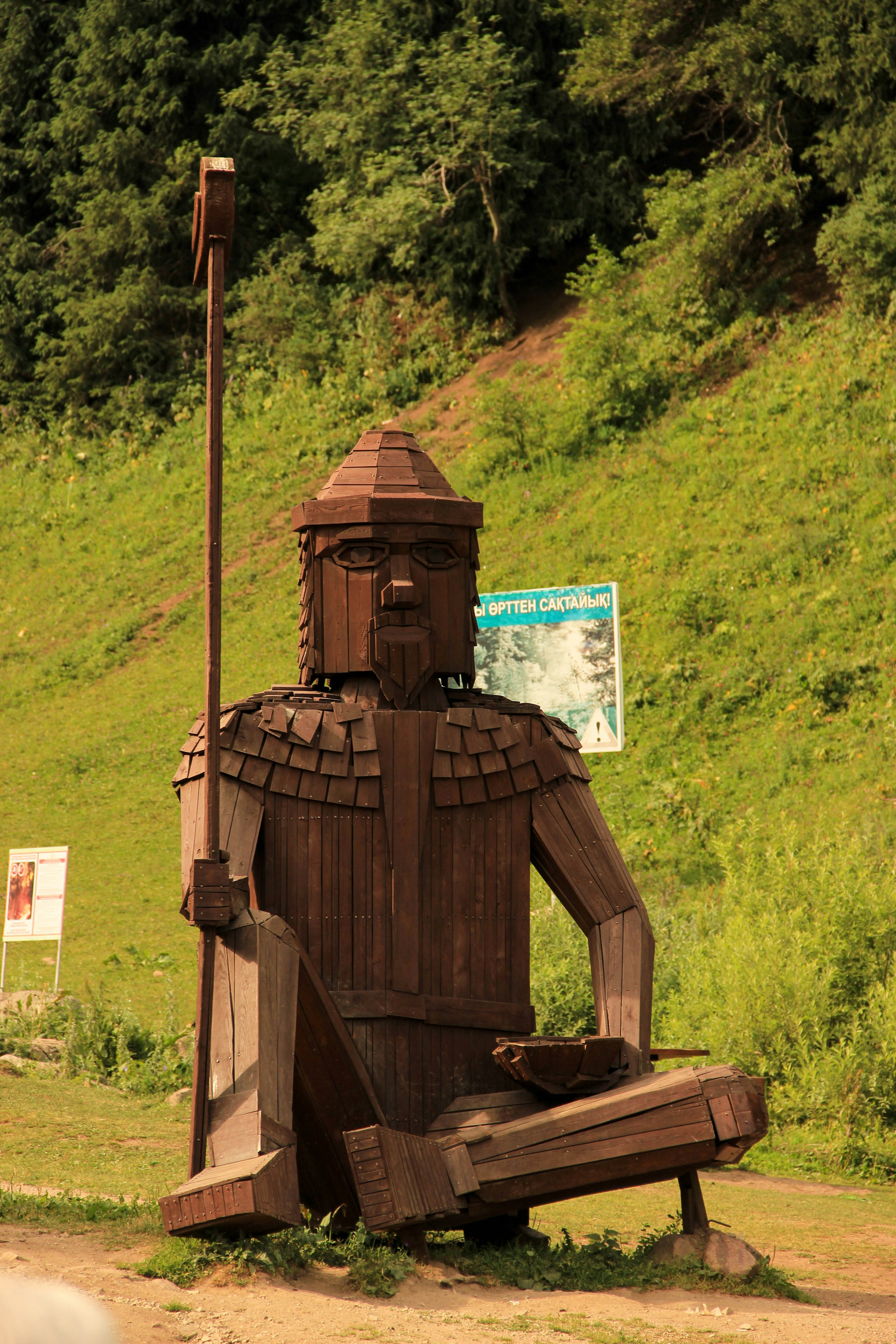 Timber Sentinel: A Seated Warrior Guarding the Green Hill