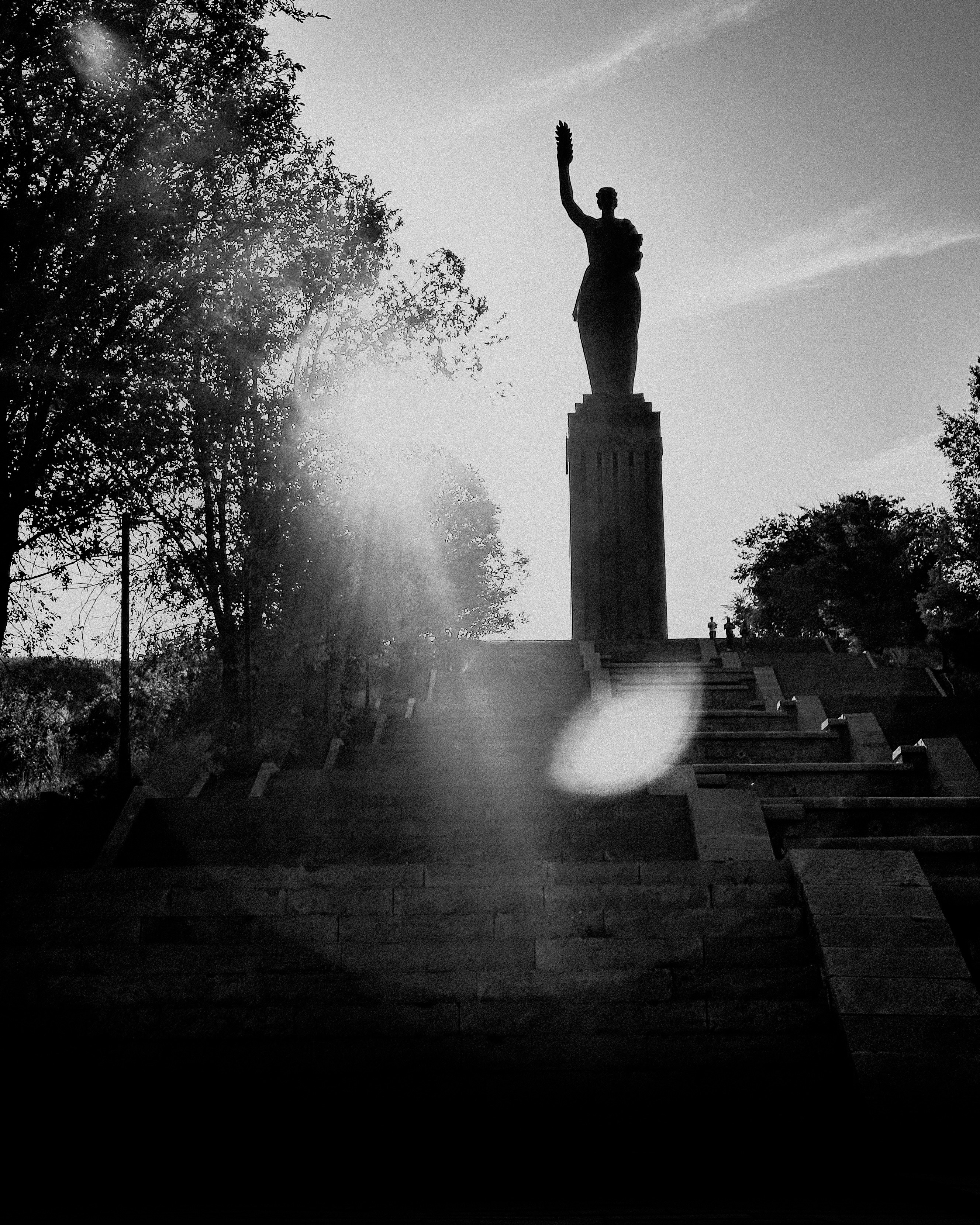 Monument to the Fallen in the Great Patriotic War (Mother Armenia) in Gyumri, Armenia. | A statue silhouetted against the bright sun.