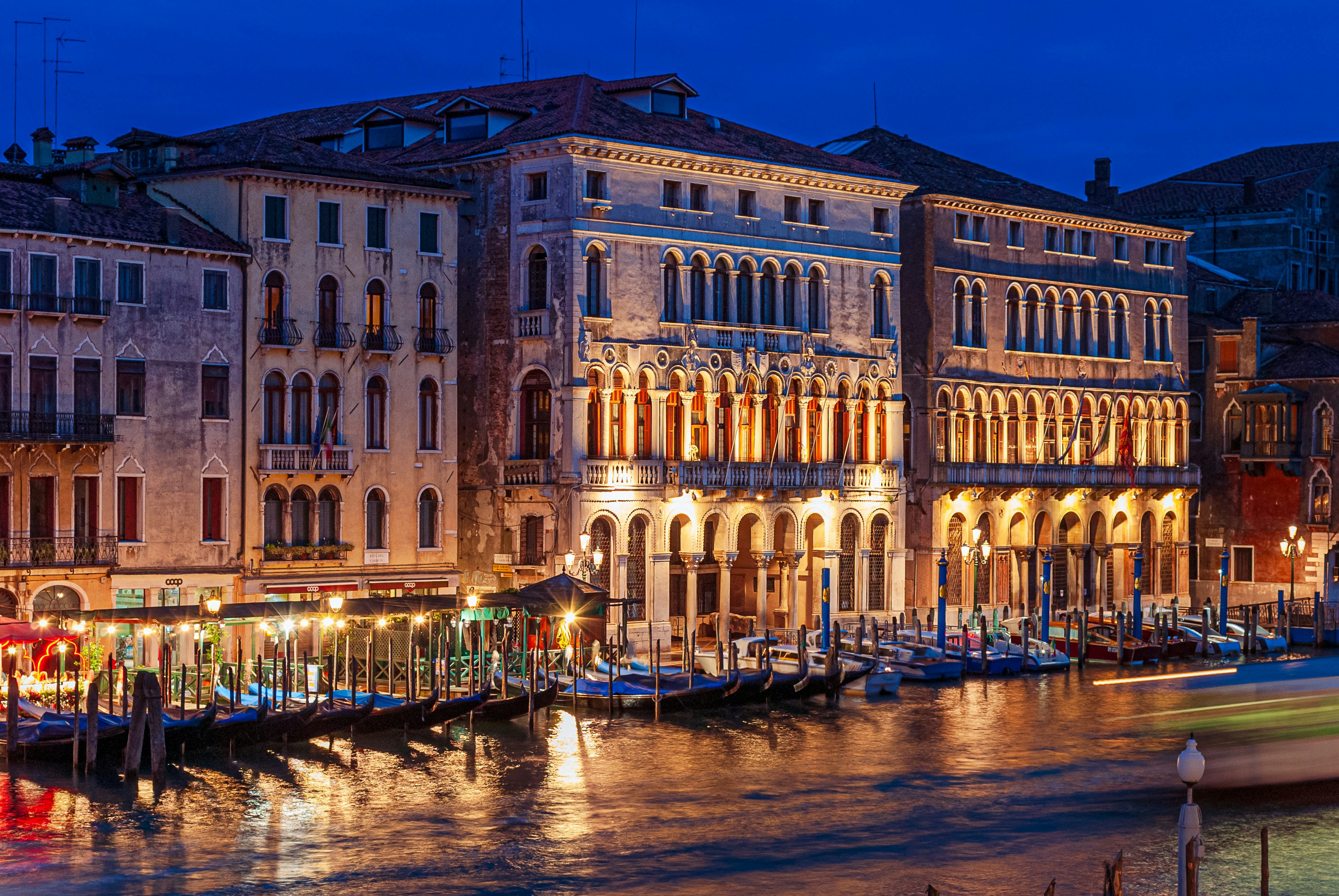 Venice in the evening on the Grand Canal | Buildings illuminated over a canal in venice at night.
